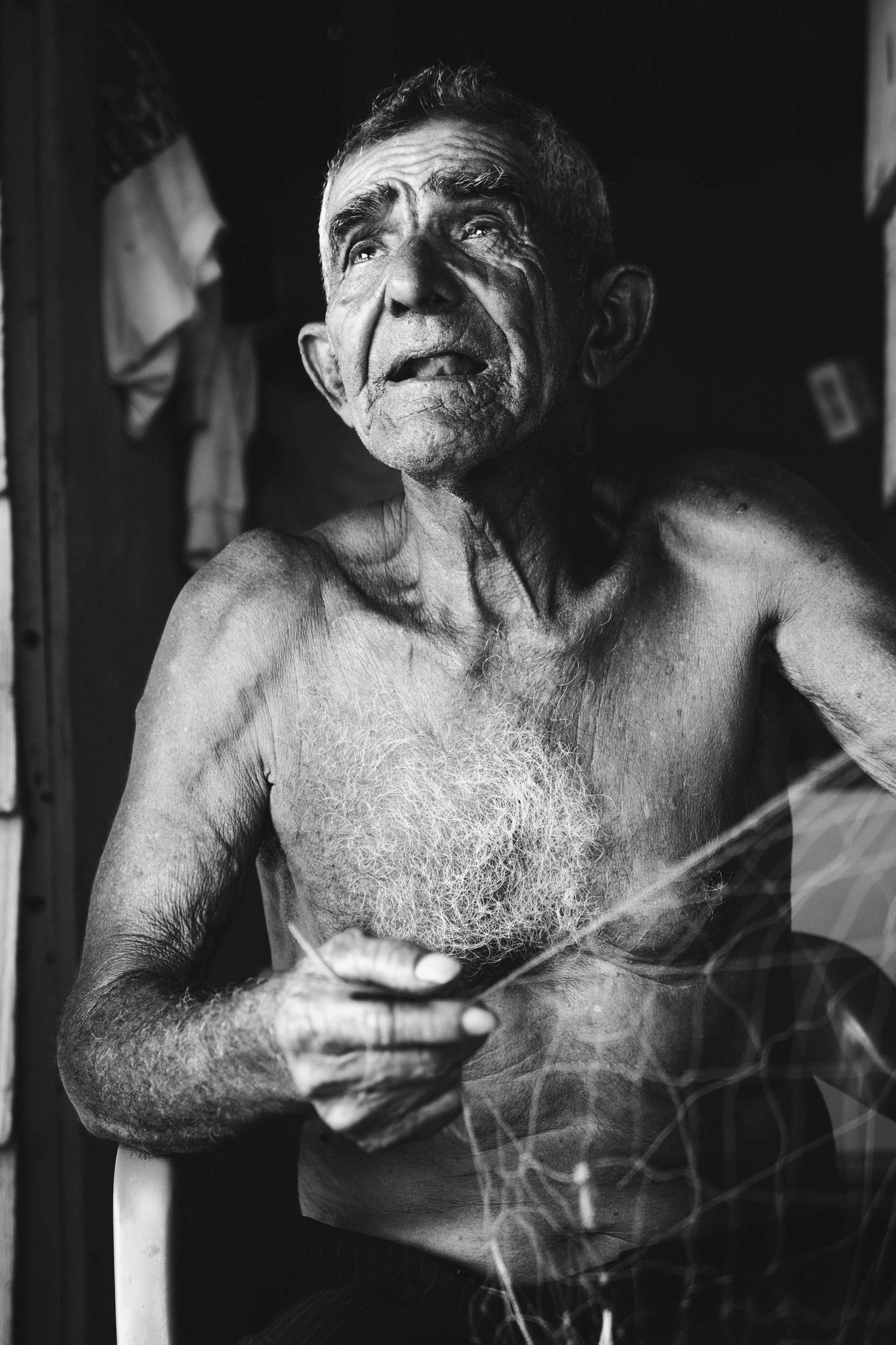 Worn Wisdom: A Gnarled Portrait Beneath Dim Light
