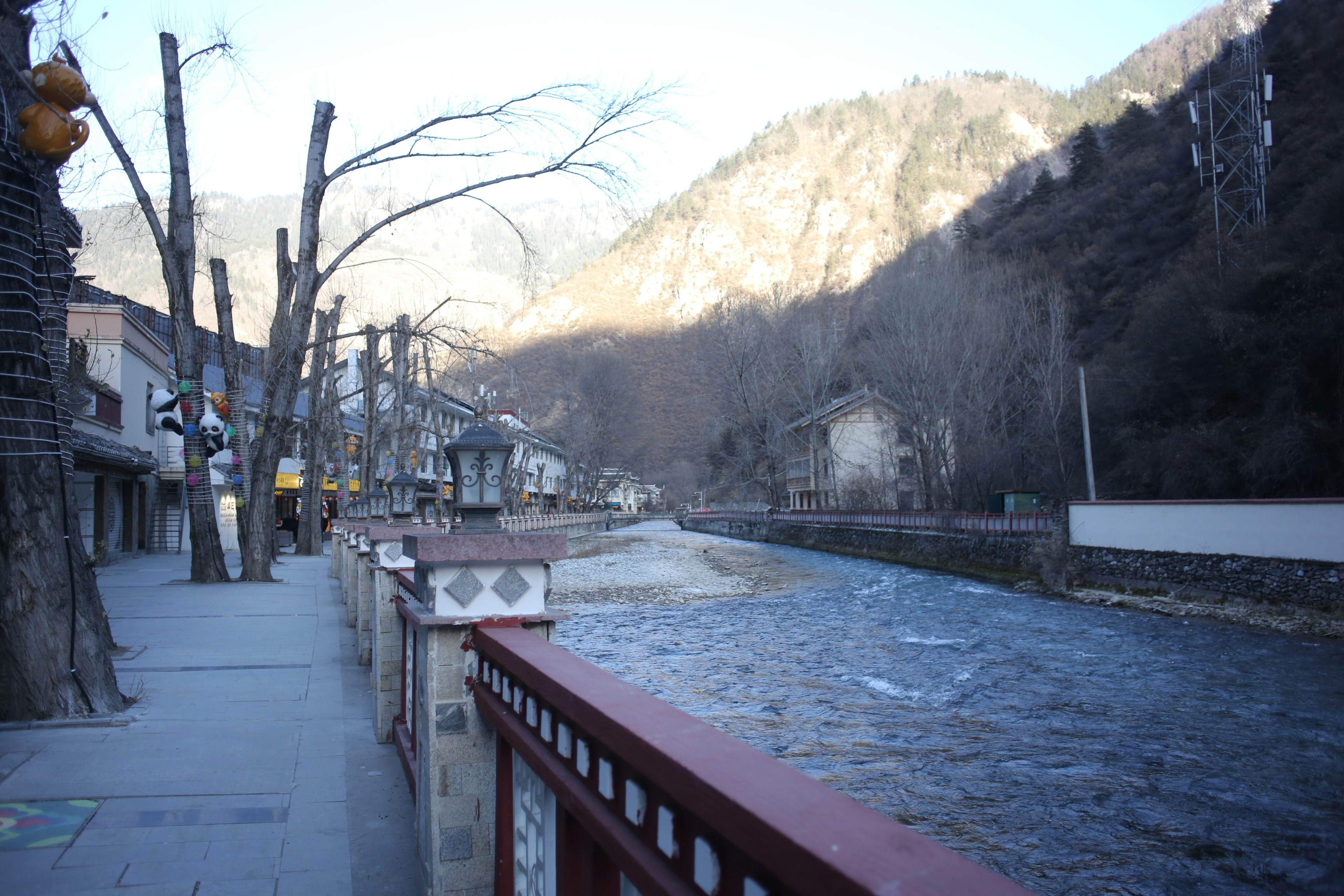 Riverside Lanterns and Walkway Amid Mountain Shadow