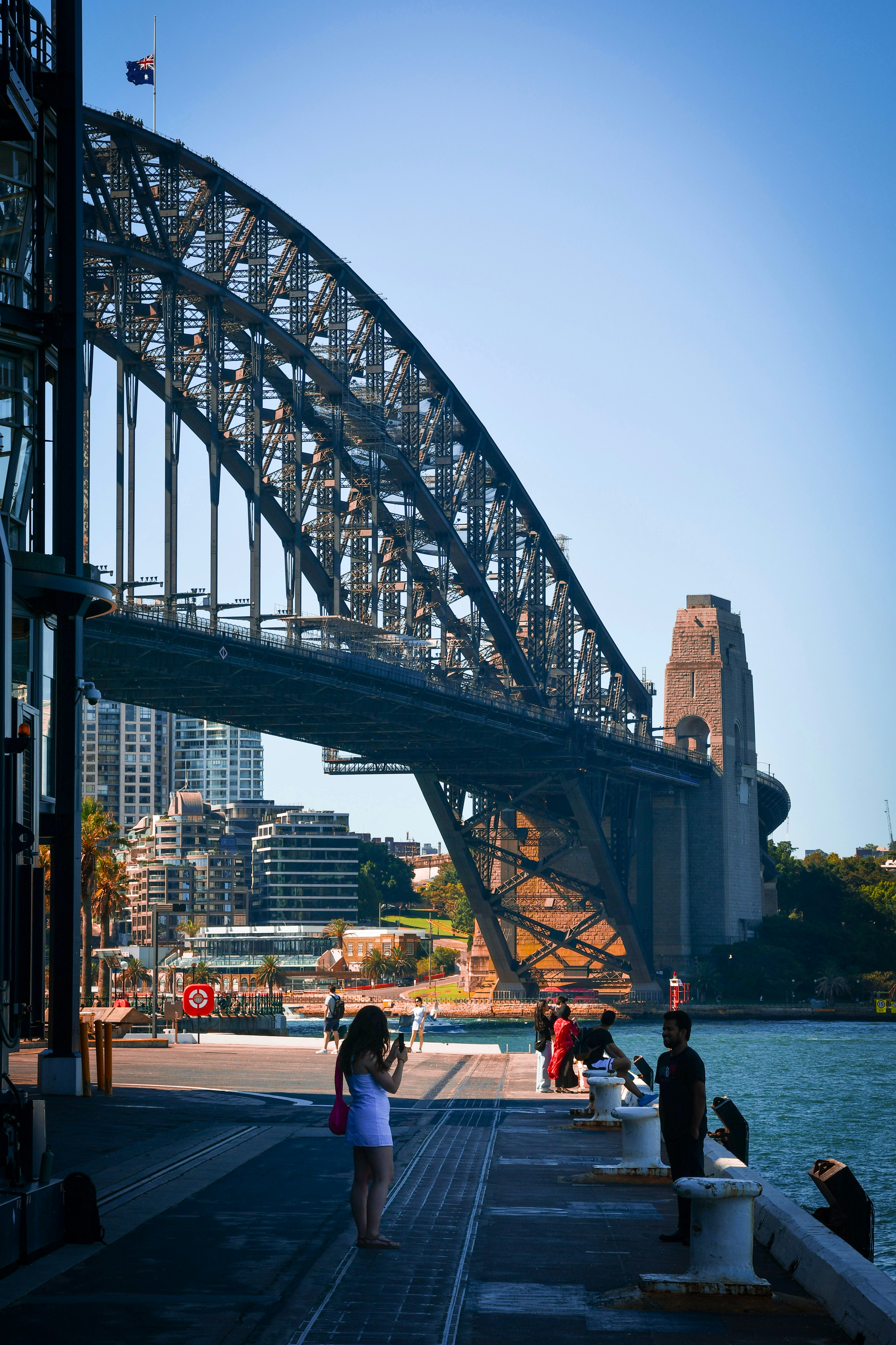 Bridge over the quay: silhouettes and steel under a clear blue sky