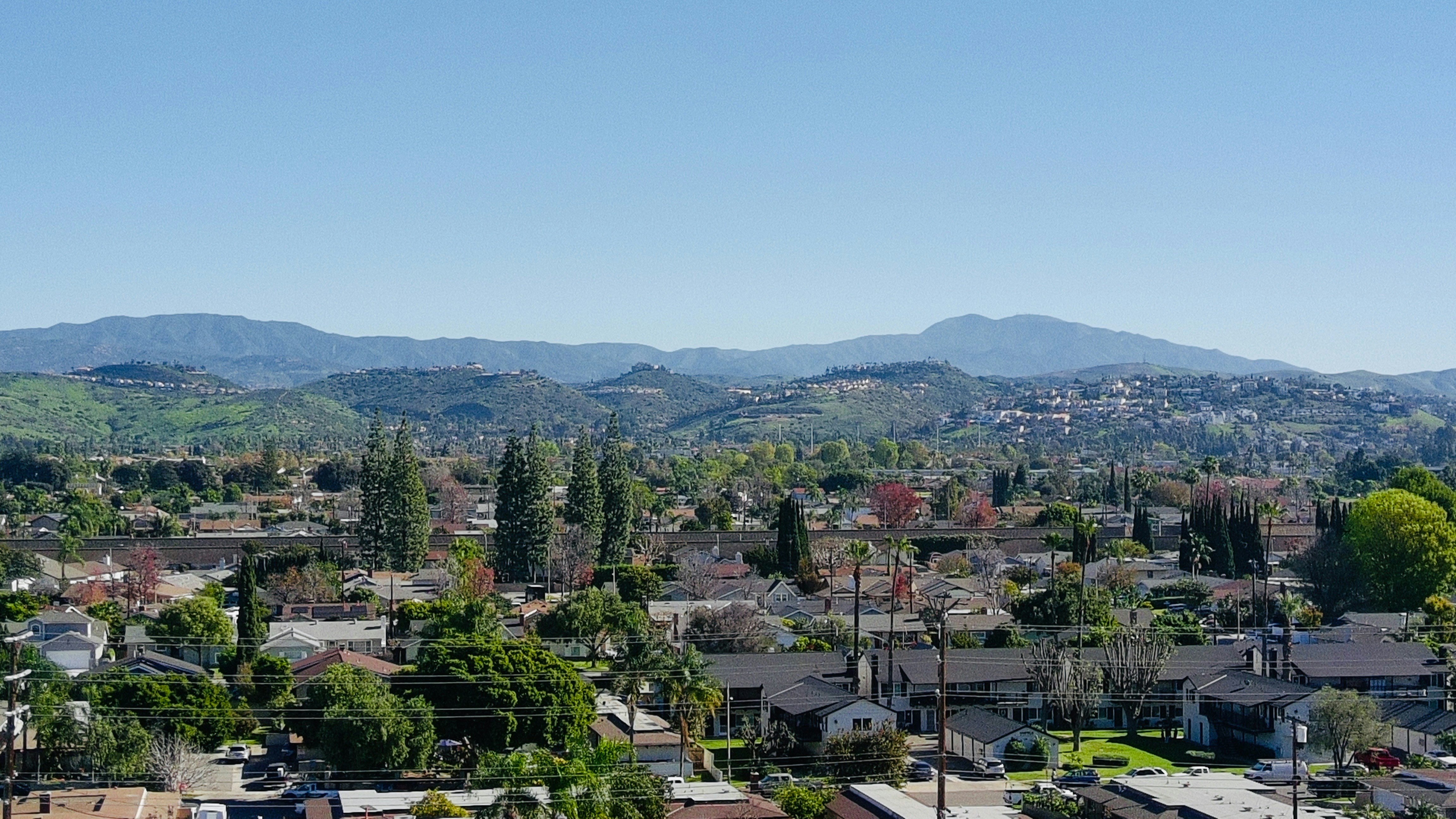 Suburban neighborhood with distant rolling hills under clear sky.