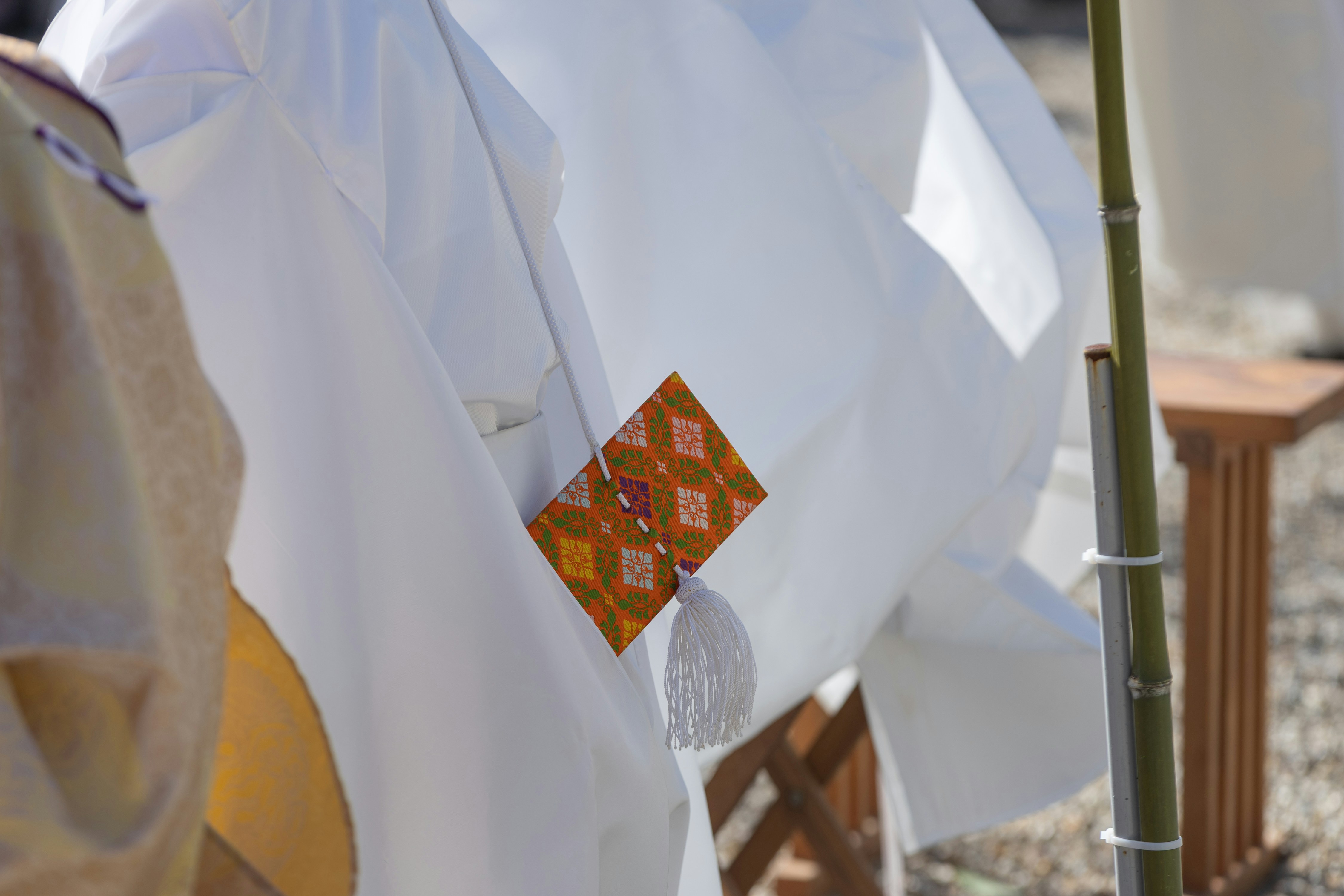 Embroidered Orange Diamond Adornment on White Ceremony Garb