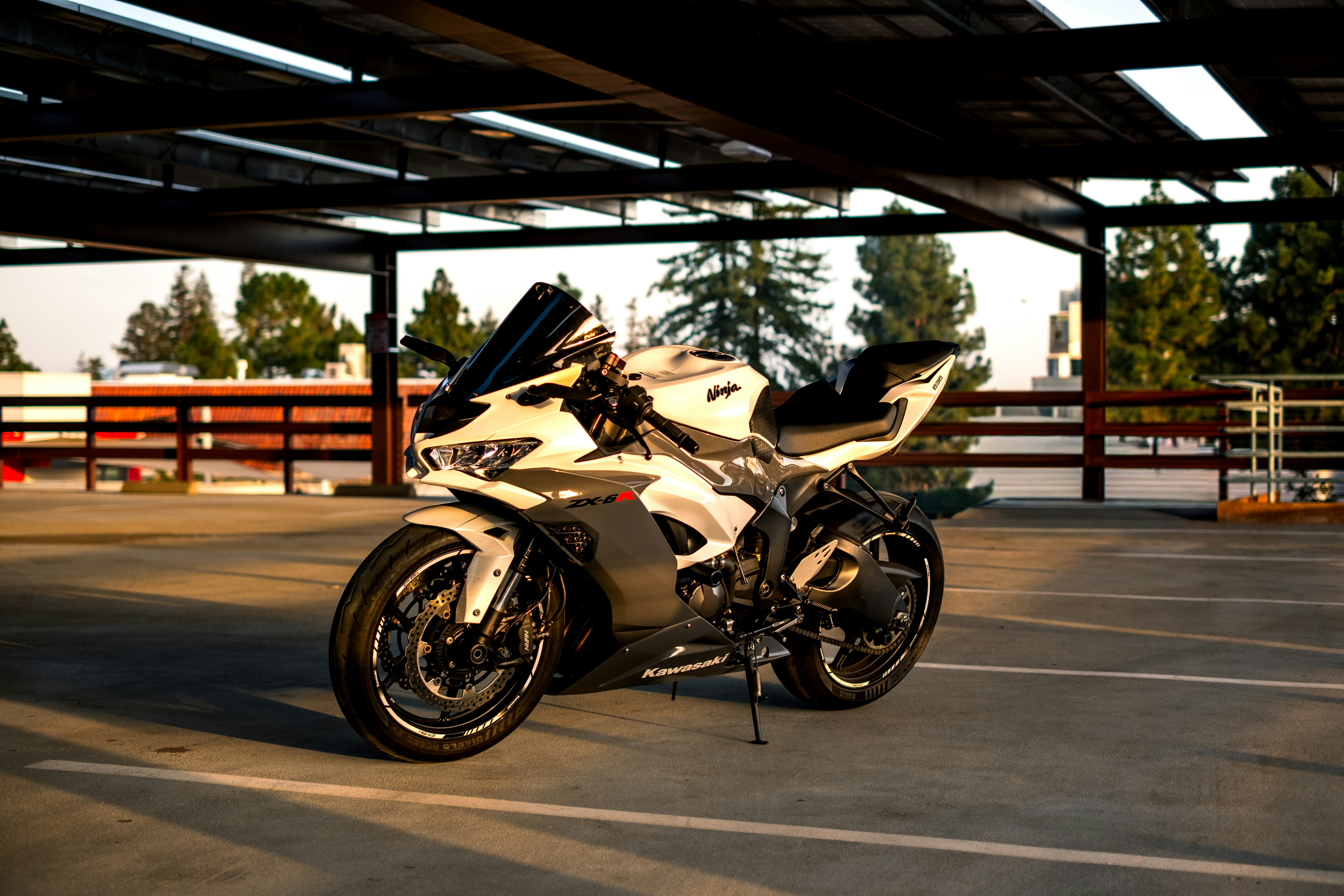 White sportbike under an open-roof garage bathed in late-day light