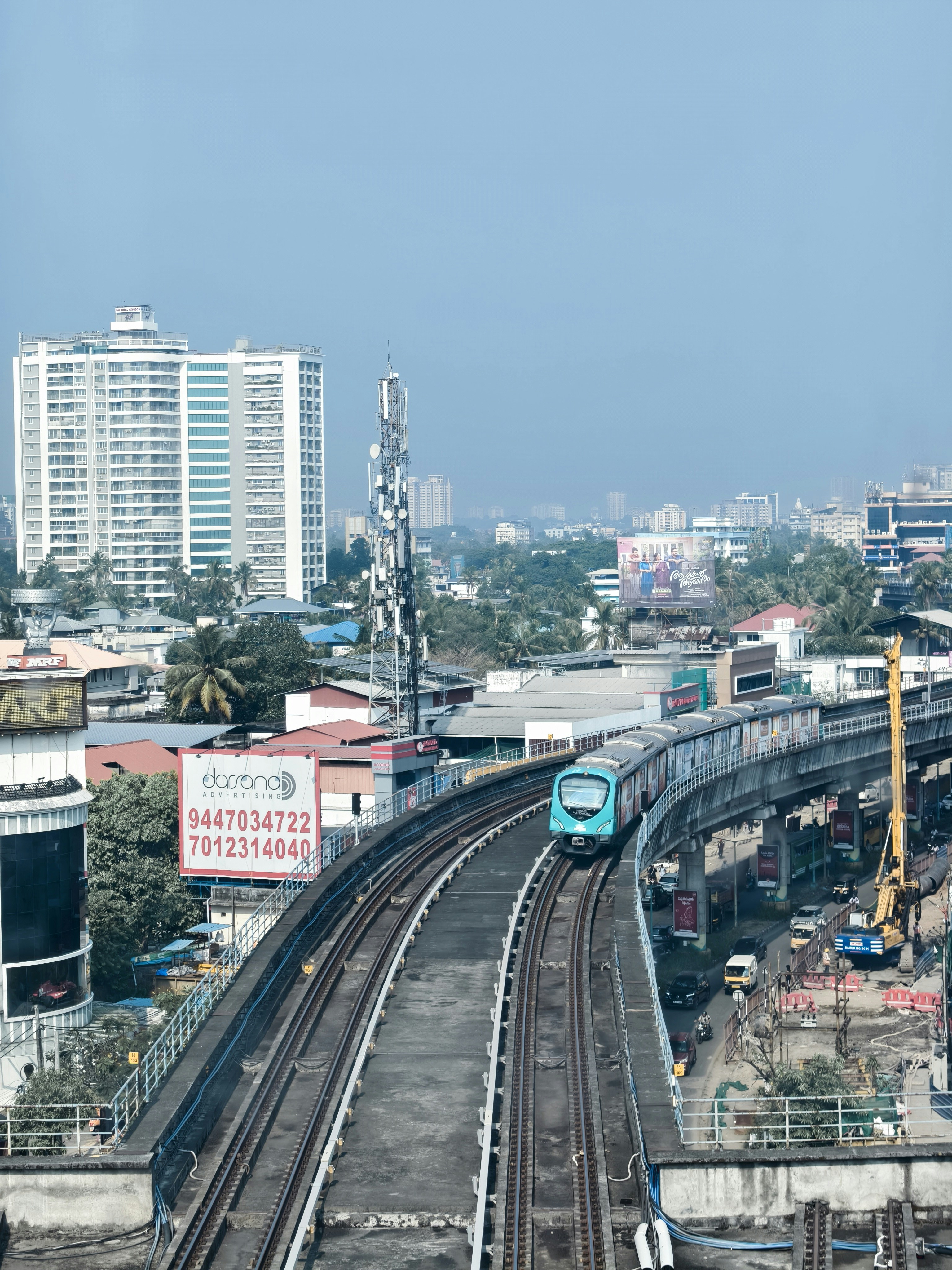 A modern train travels on elevated tracks through a city.