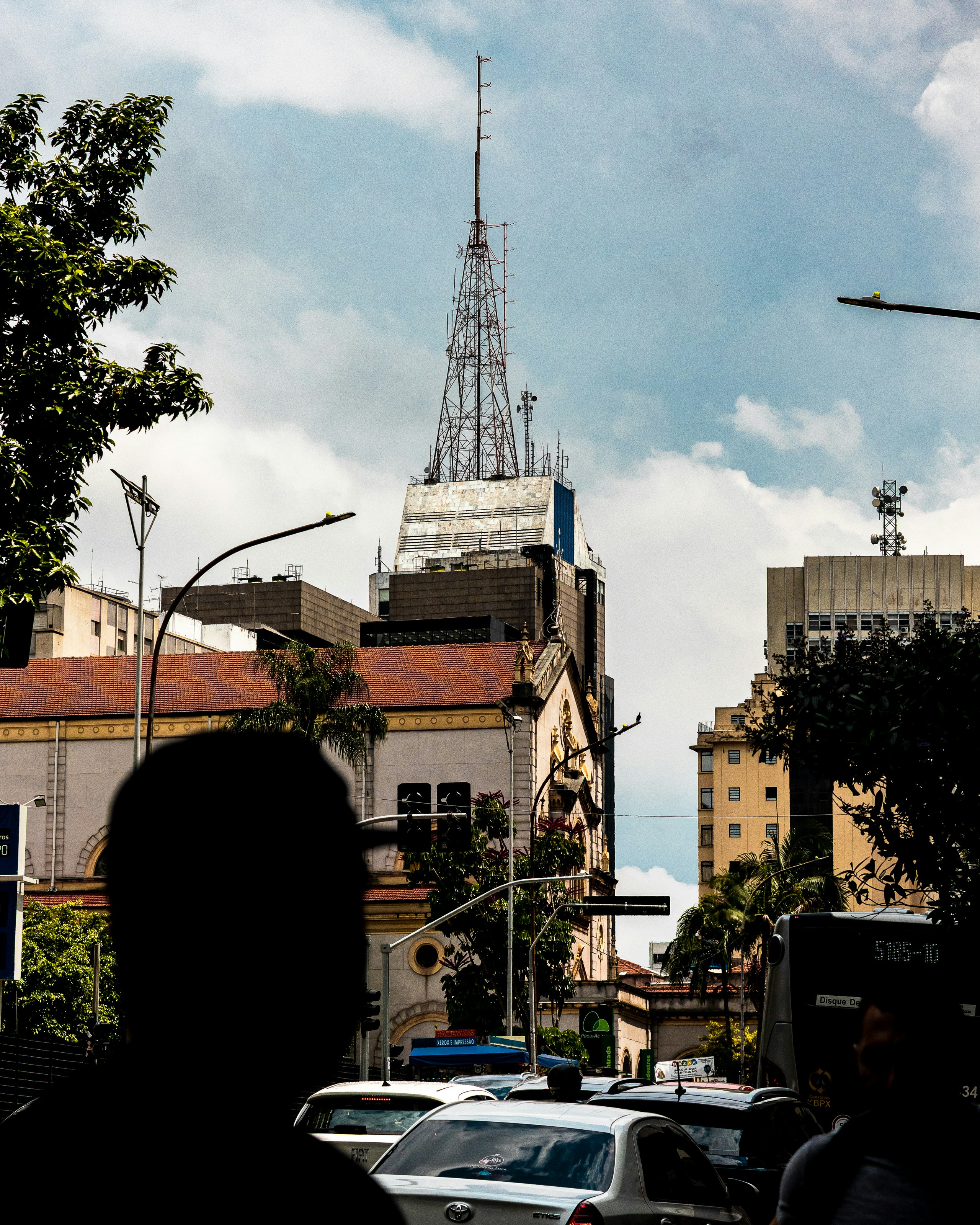 Urban Skyline Under a Towering Antenna: Street-Level Portrait of a Busy City