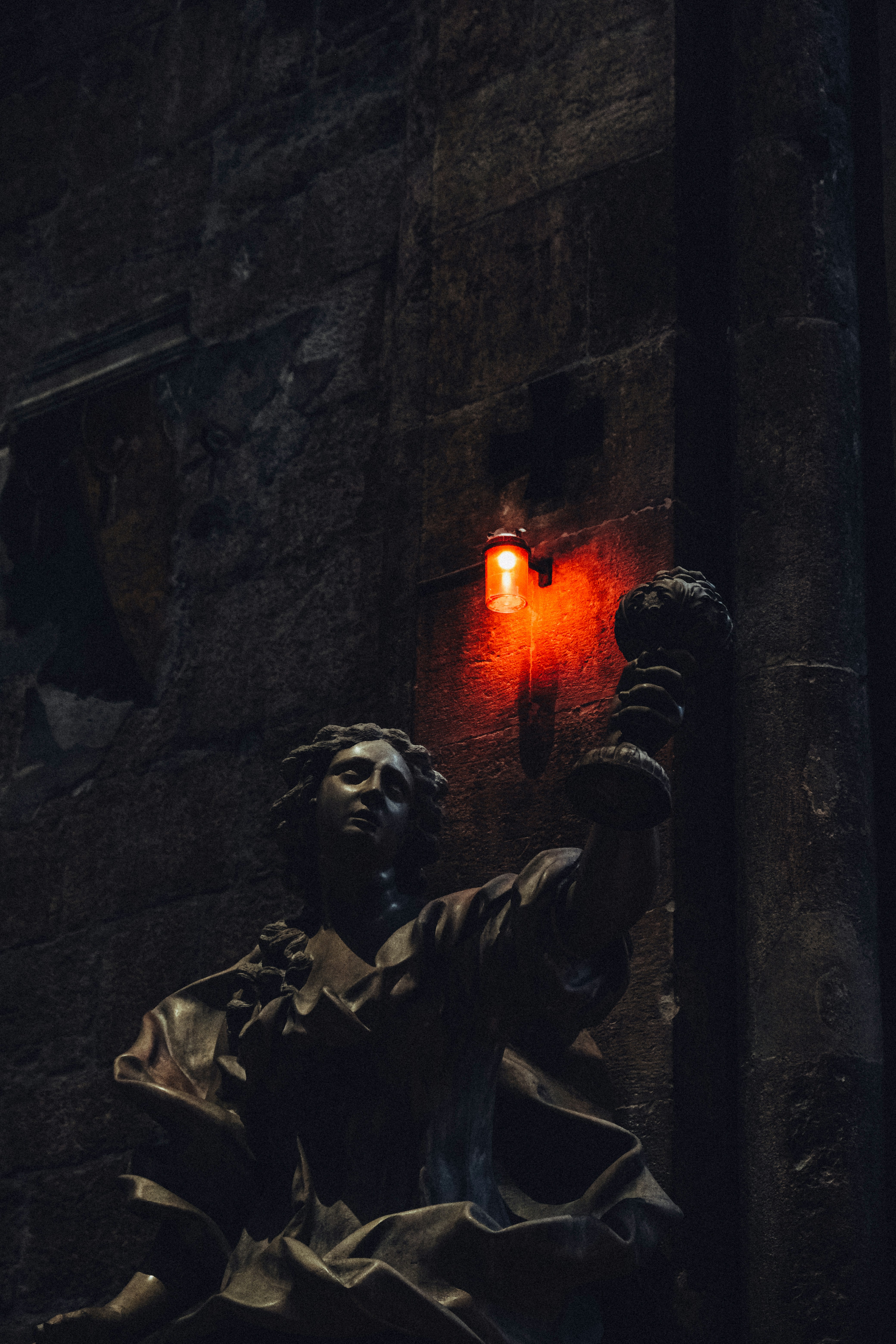 Gloomlit Justice: A Statue Under the Red Glow