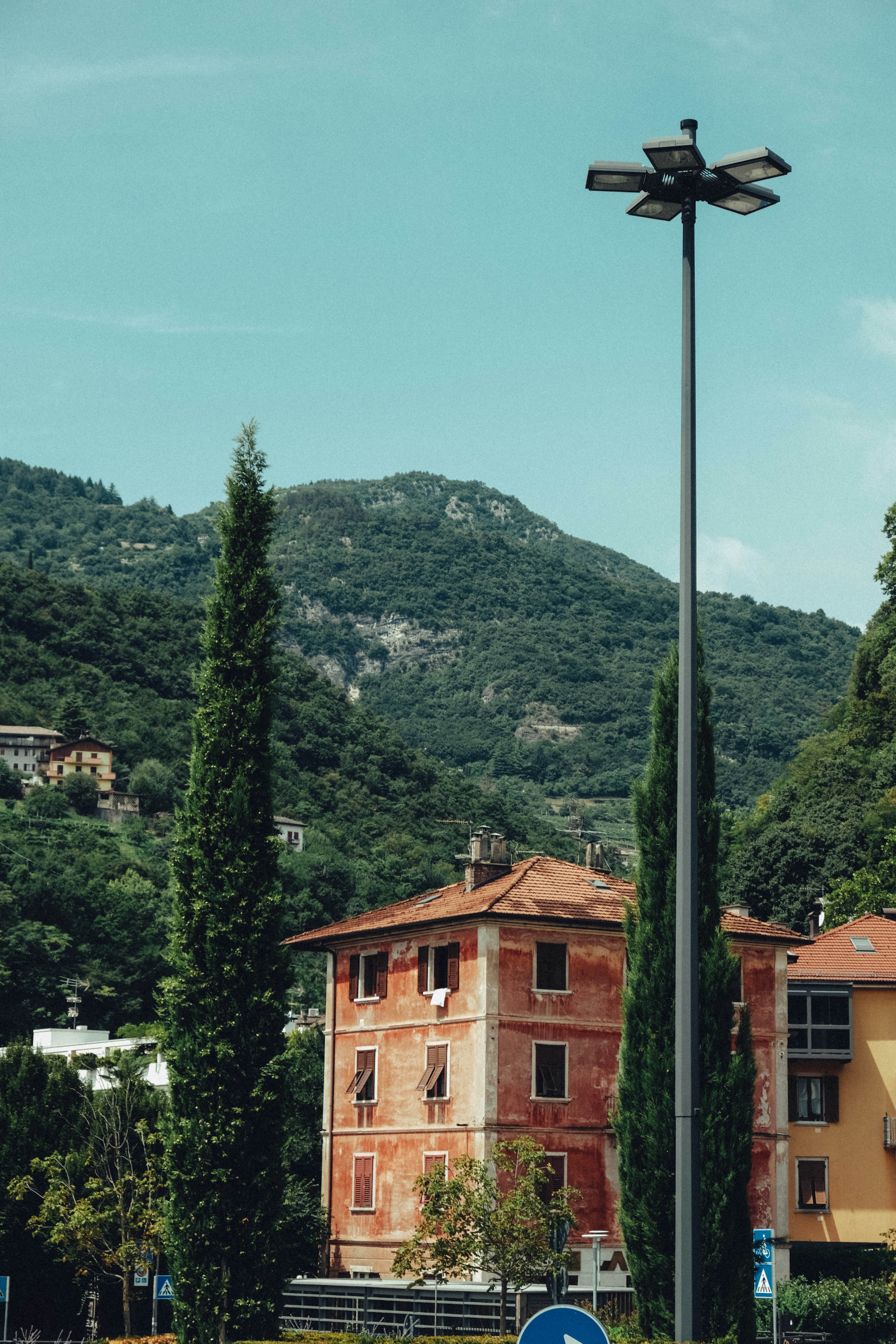 Tall Streetlamp Overlooking Rustic Village Against Alpine Backdrop