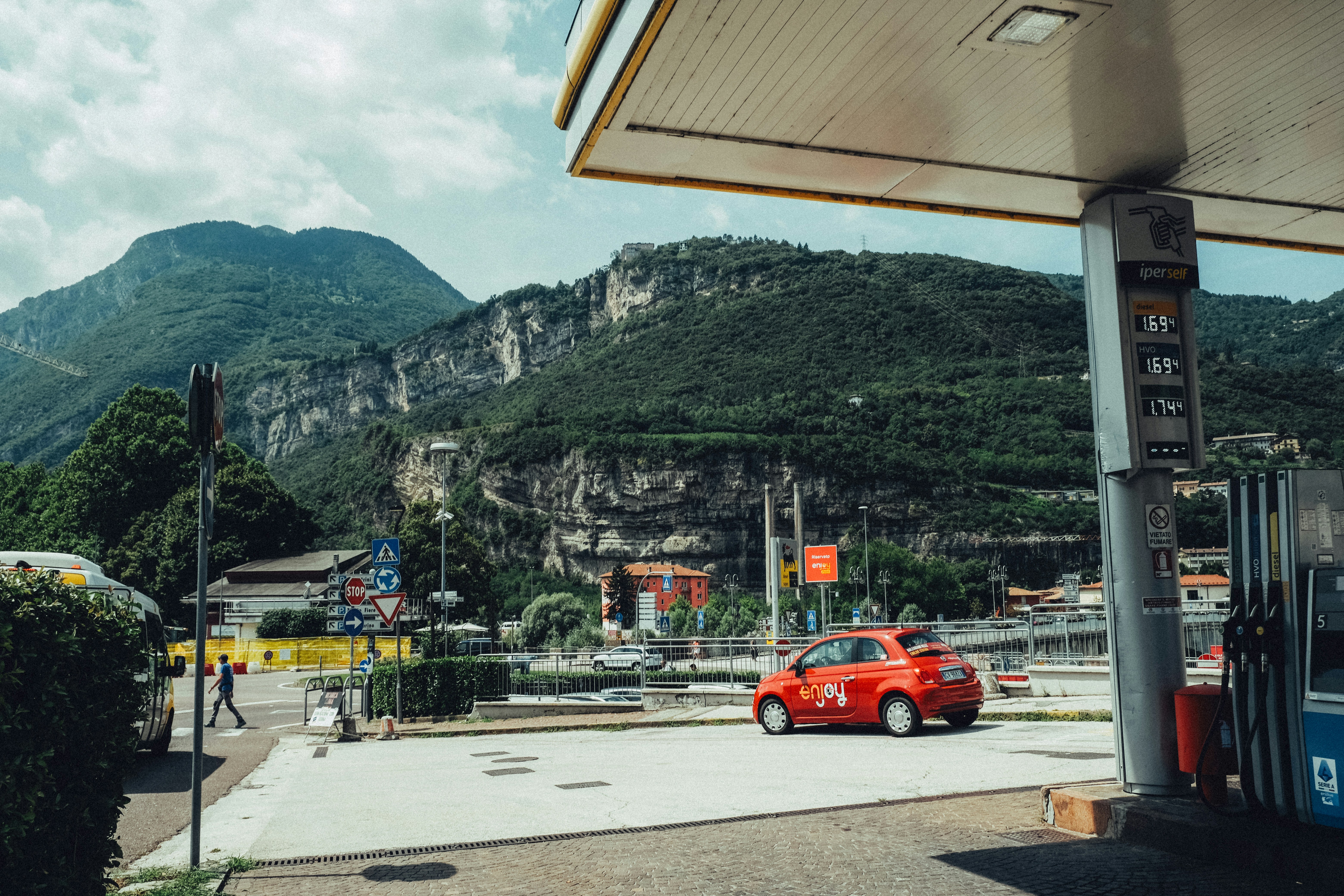 Red Taxi Crossing the Footbridge Against Mountain Backdrop