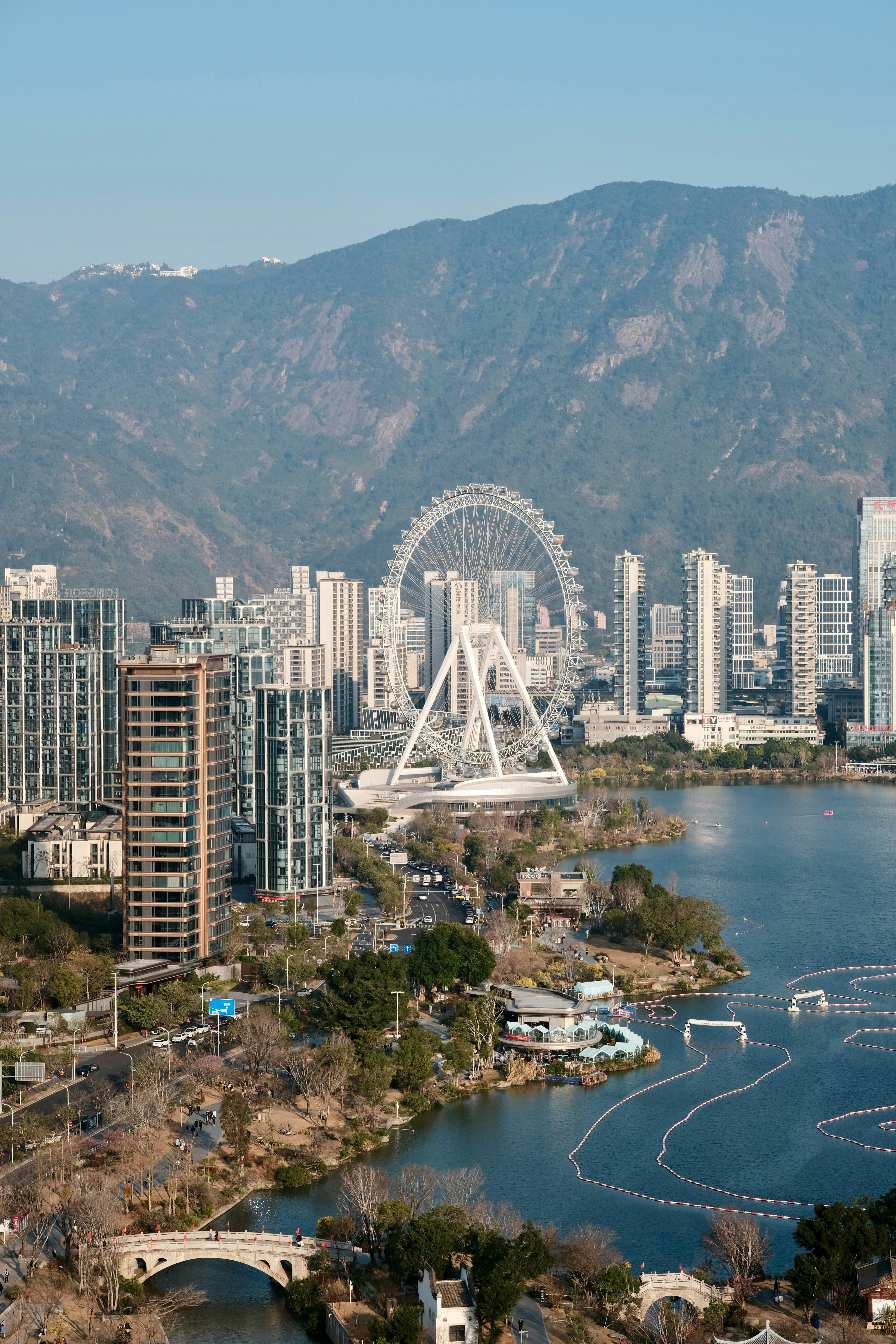 City by the Sea: A Giant Wheel Framed by Glass Towers