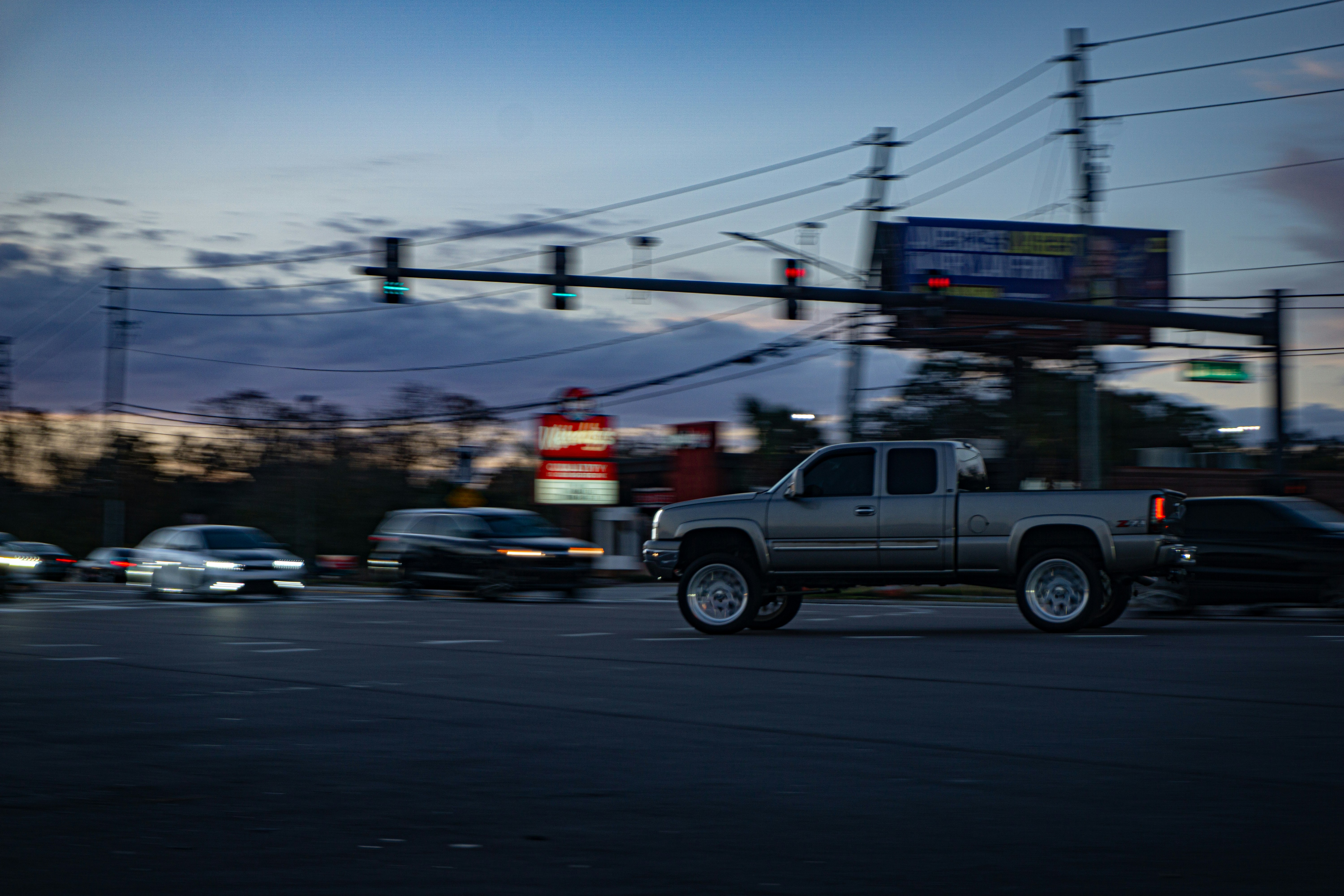 Evening Arc: A Fleet of Cars Under Slow Traffic Lights