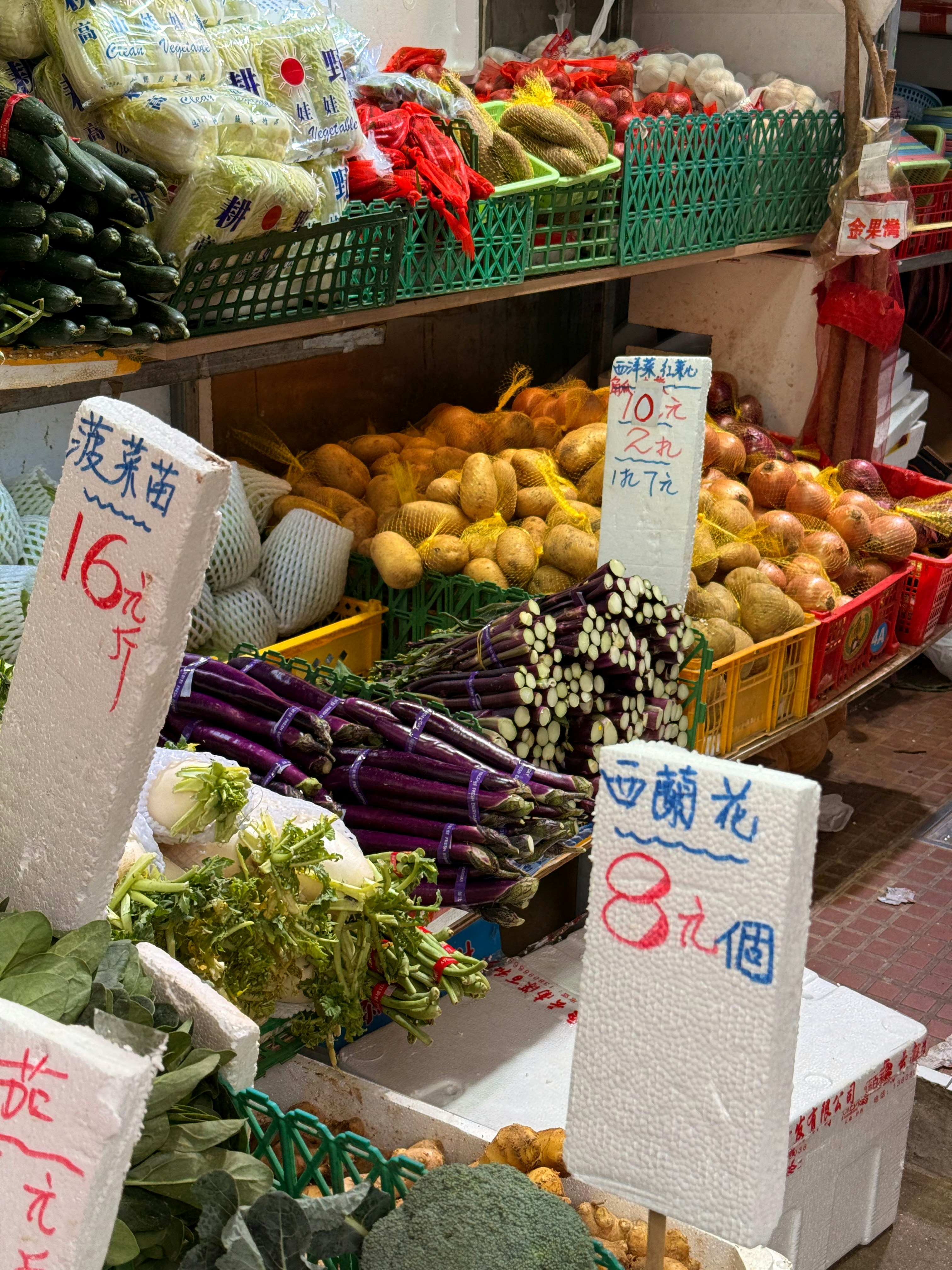 Vibrant Market Bounty: Stacked Produce under Fluorescent Watchful Shelves