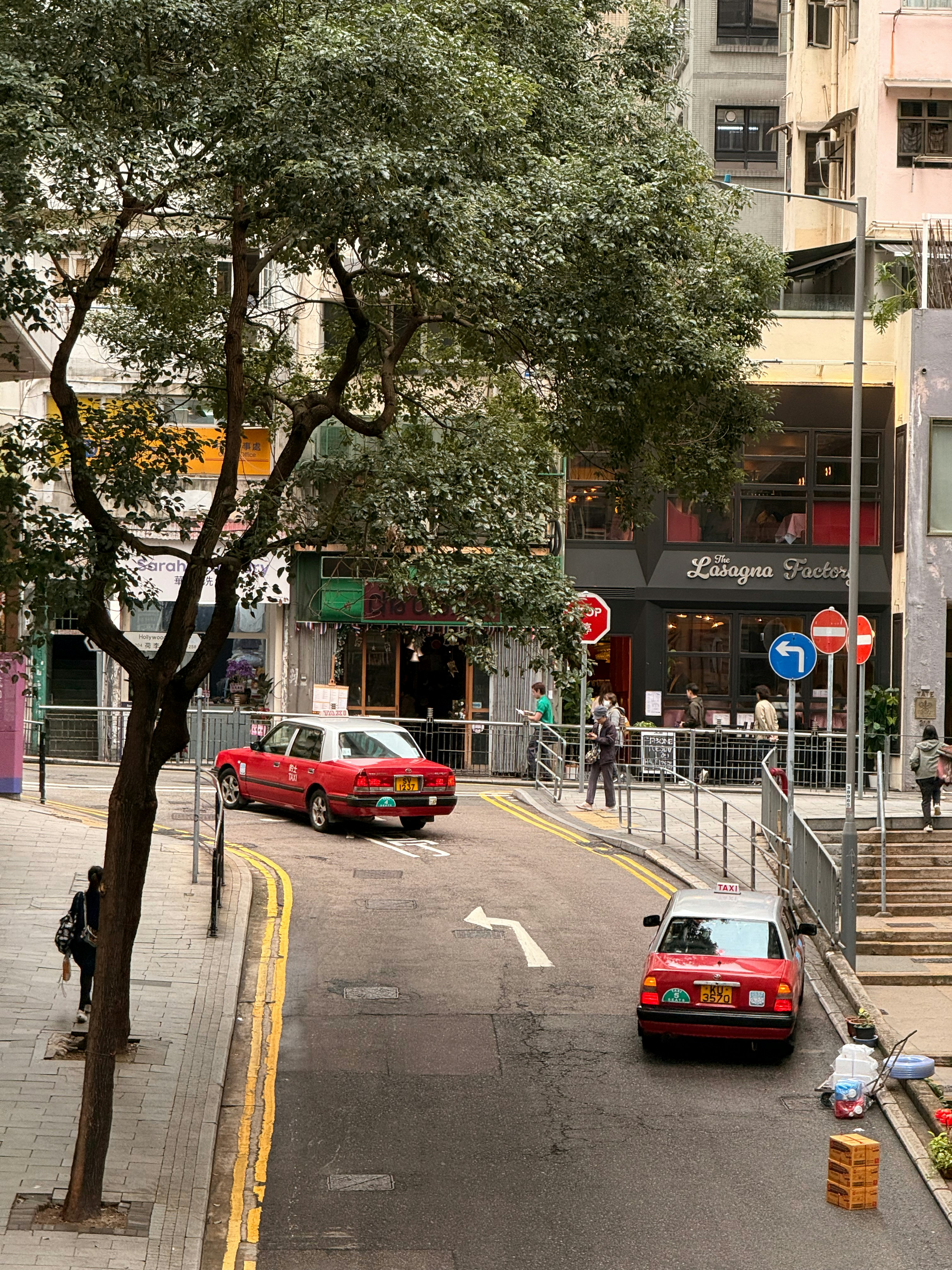 City Street with Red Taxis and Shaded Arcades