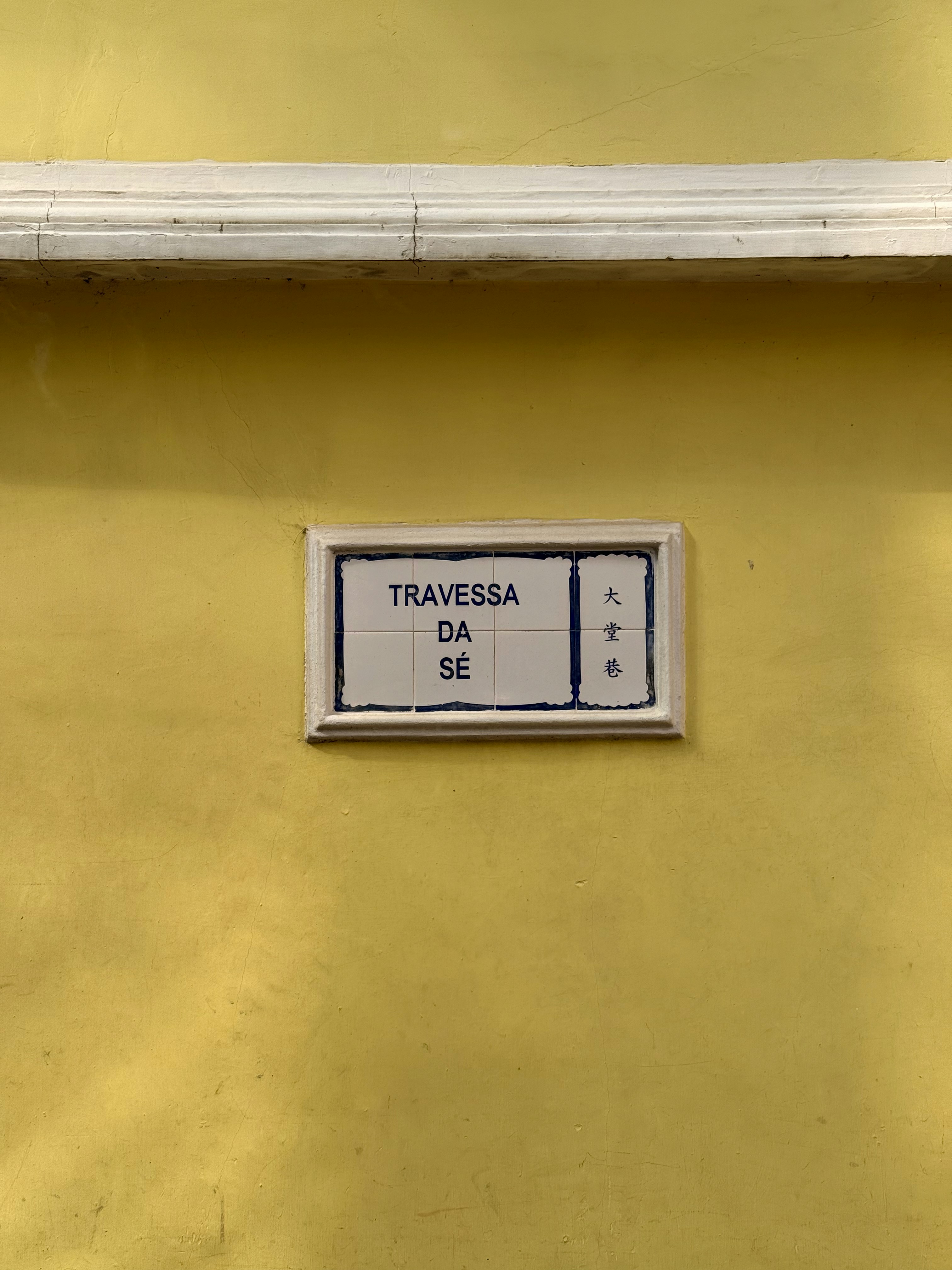 Yellow Wall, Quiet Plaque: A Street Sign Between Two Moments