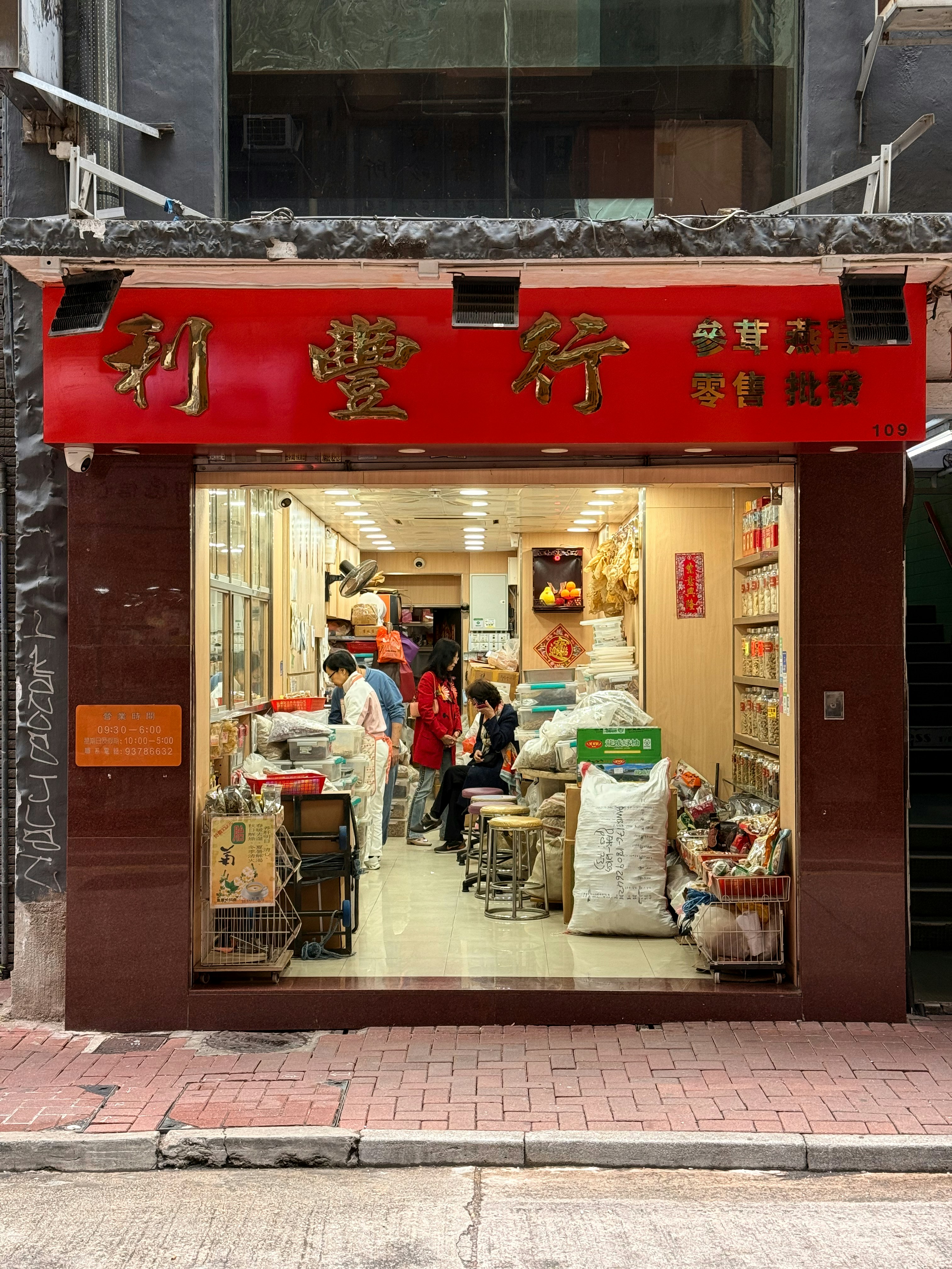 Red storefront doorway into a busy Chinese shop interior