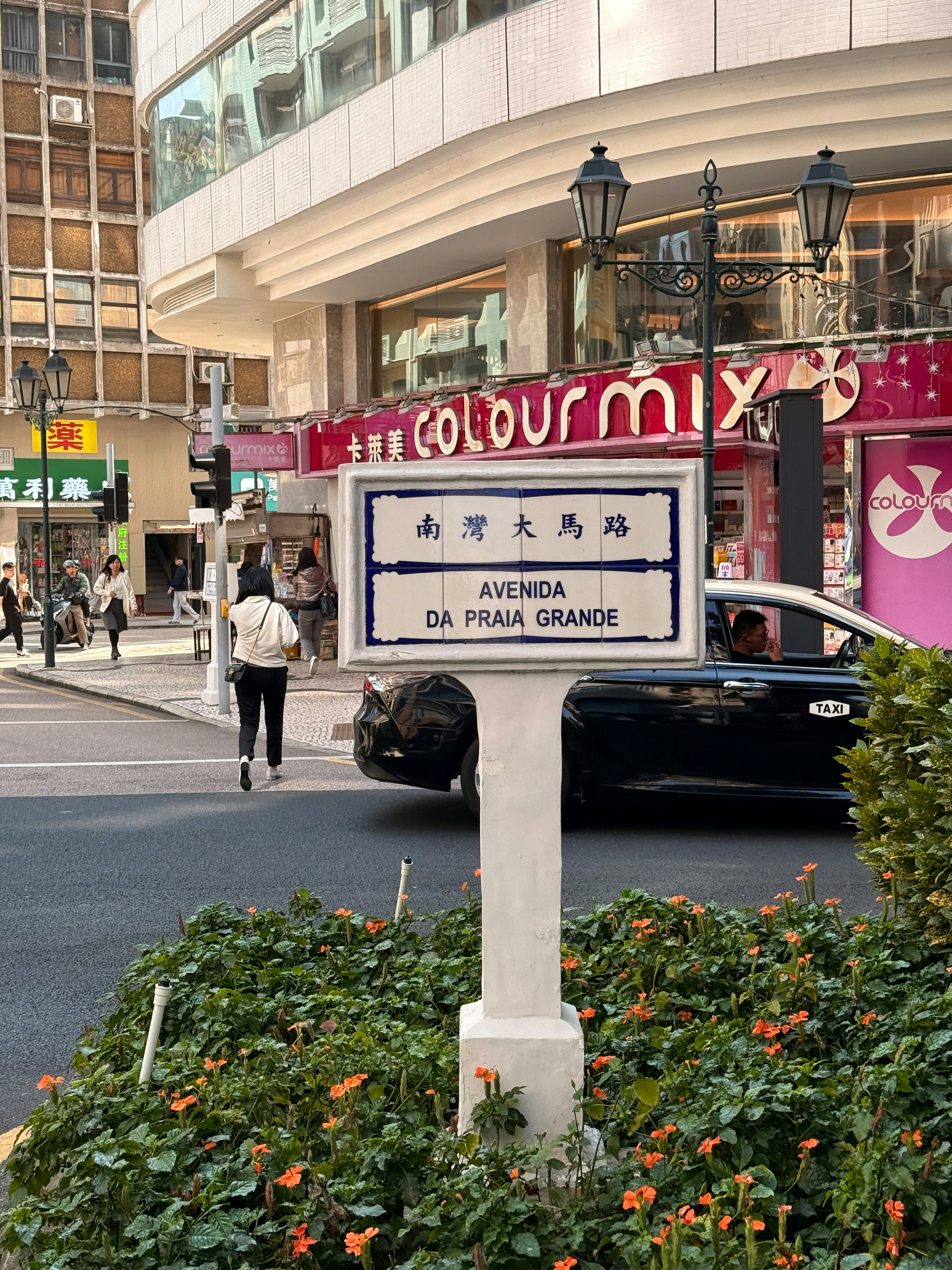 City Signpost: Avenida da Praia Grande Amid Urban Bloom