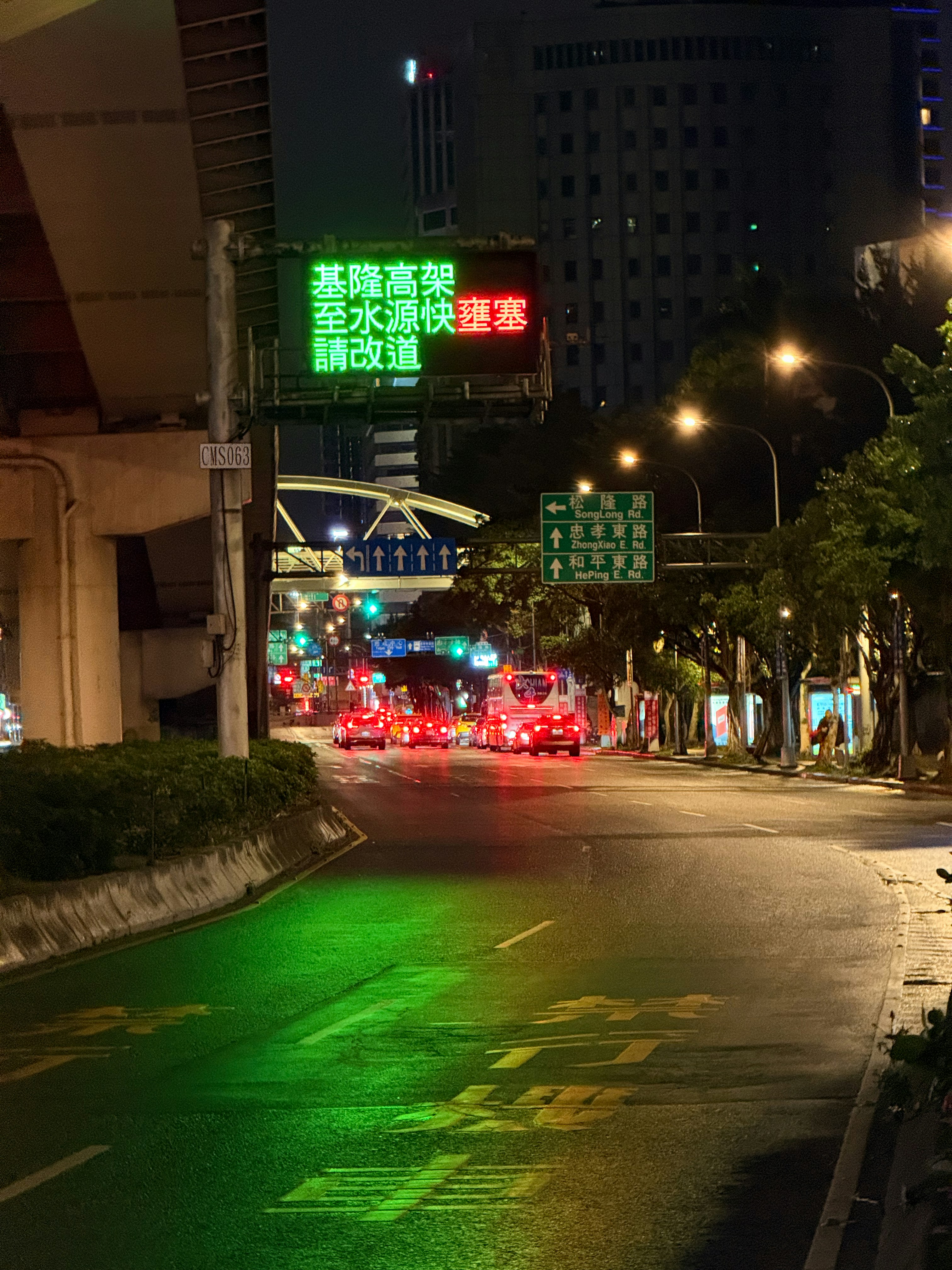 Neon Highway: Night Traffic Under Green Signage