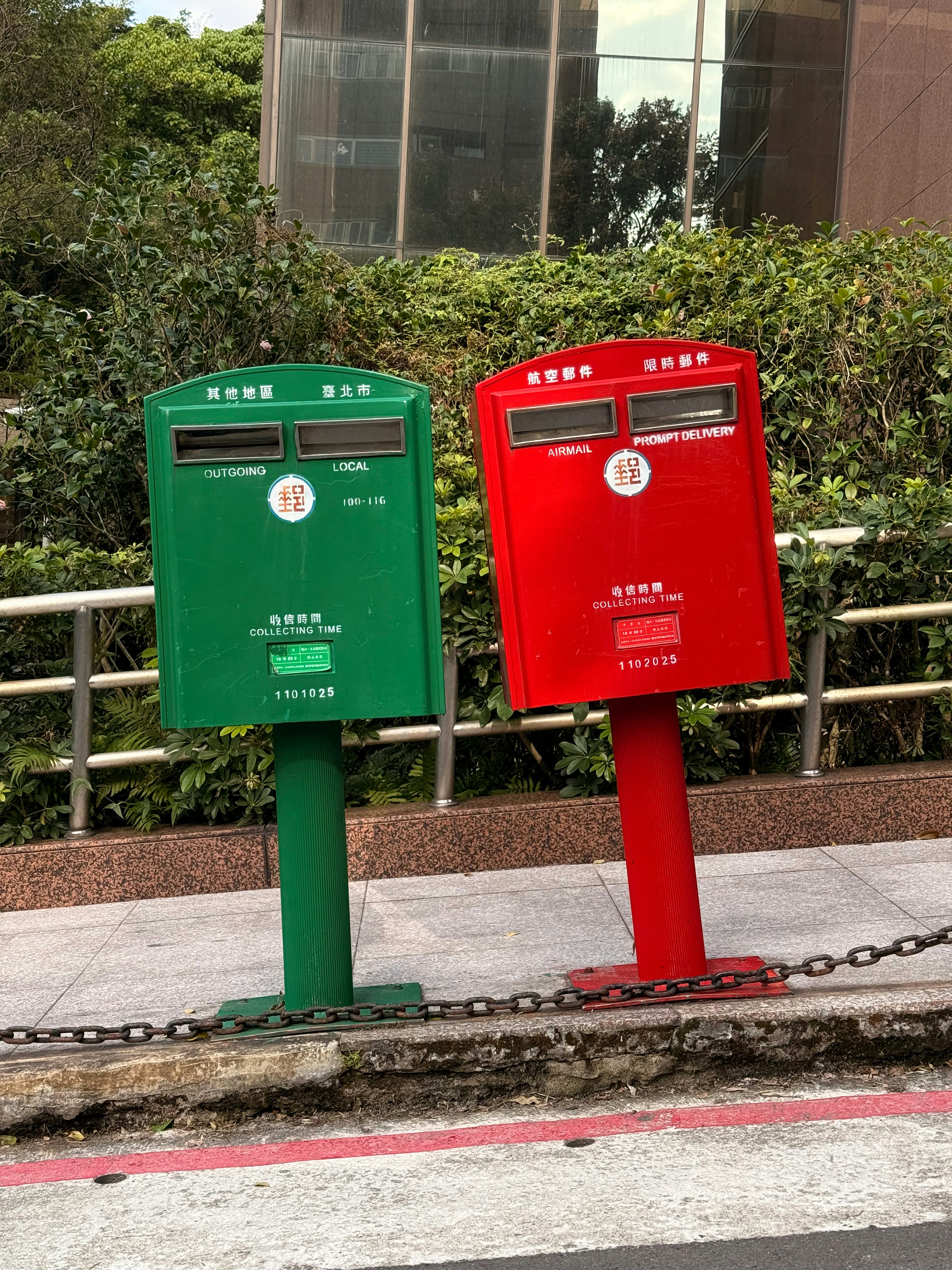 Twin Post: A Pair of Colorful Mailboxes Leaning Toward the Street