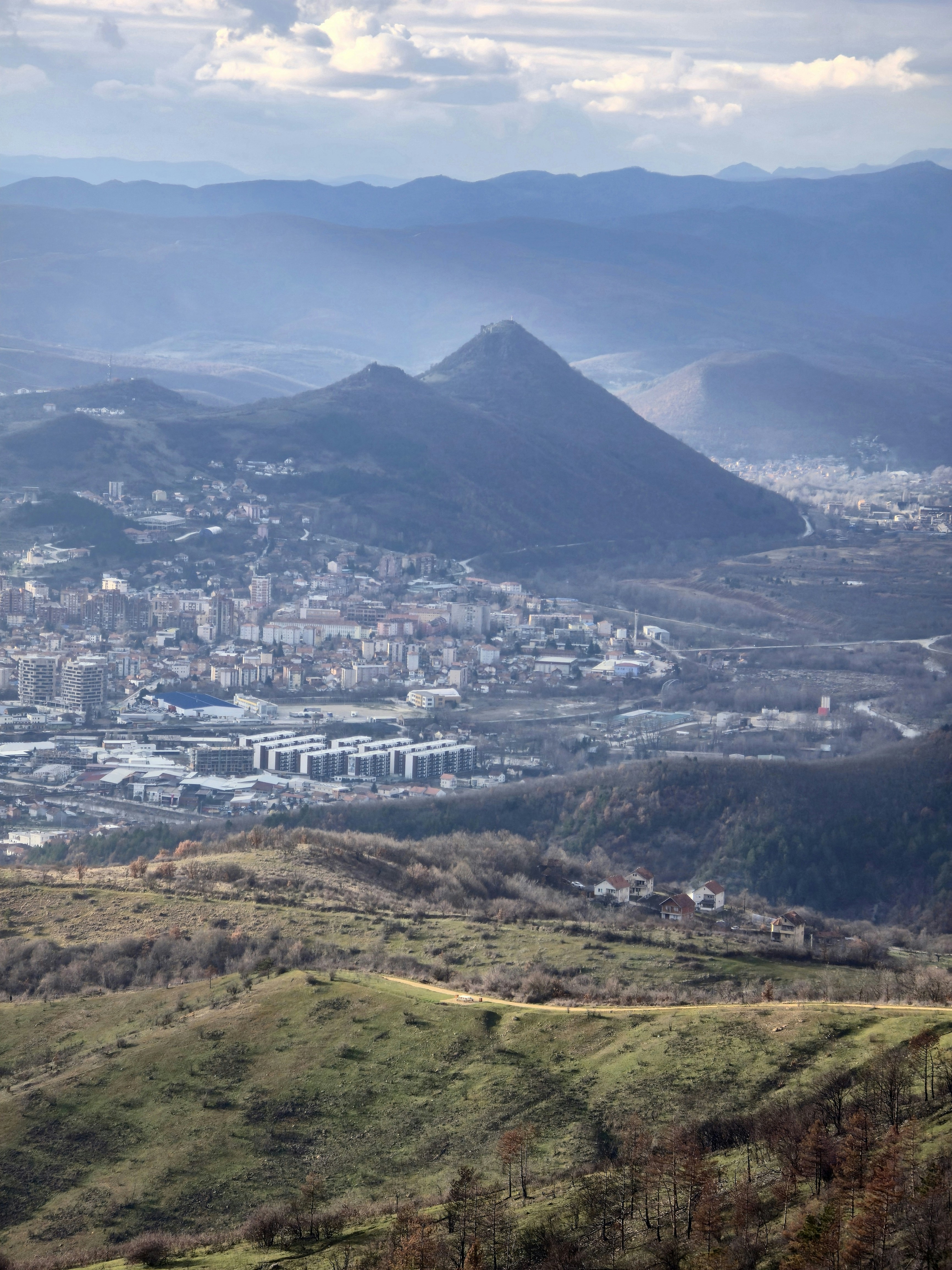Urban Valley Amid Gentle Hills Under a Layered Mist