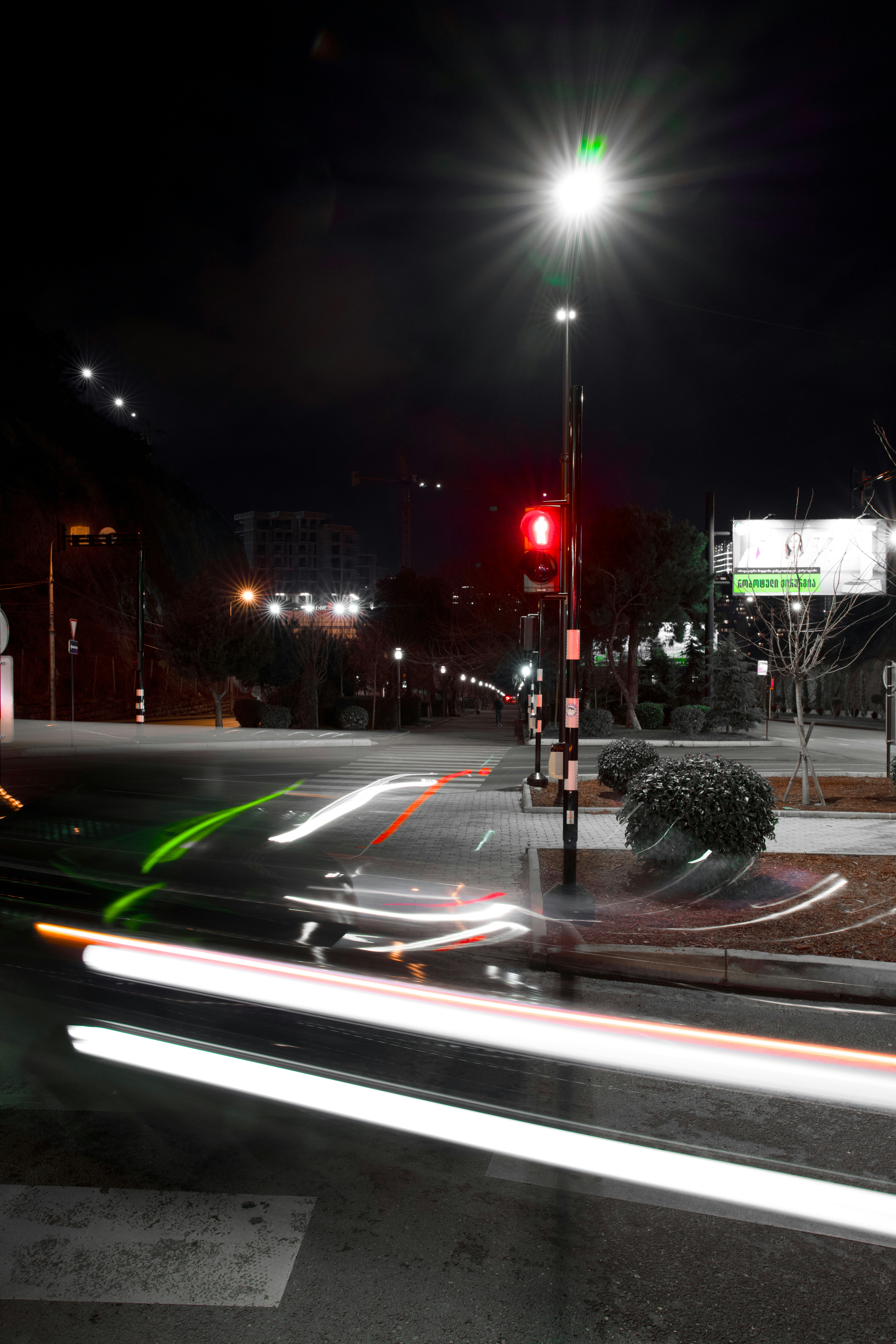 Neon Crosswalk at Night: Streaks of Motion Beneath a Red Signal