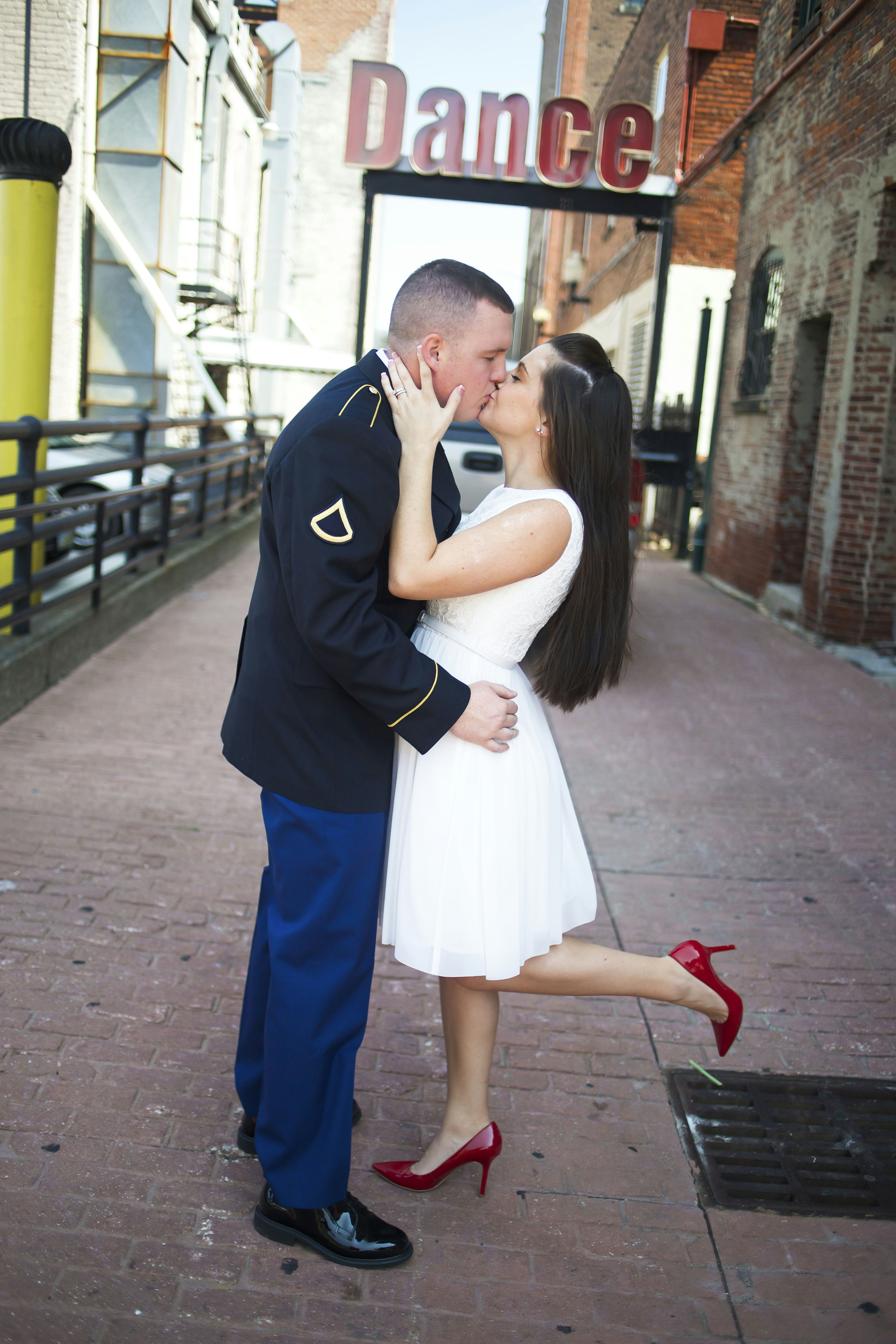 Kiss under the Dance Sign: A Romantic Moment in an Industrial Alley