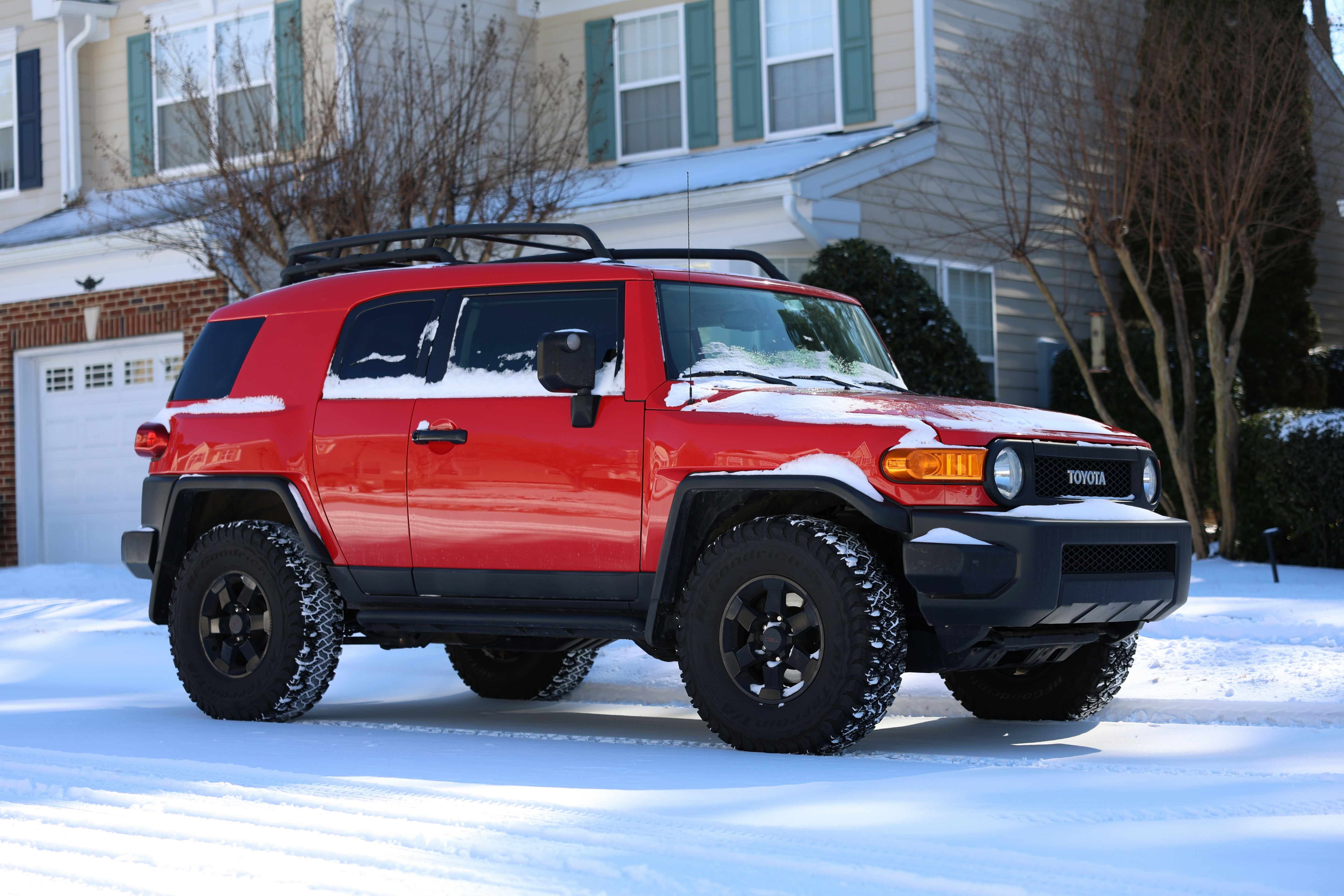 Red Toyota FJ Cruiser on Snowy Suburban Drive