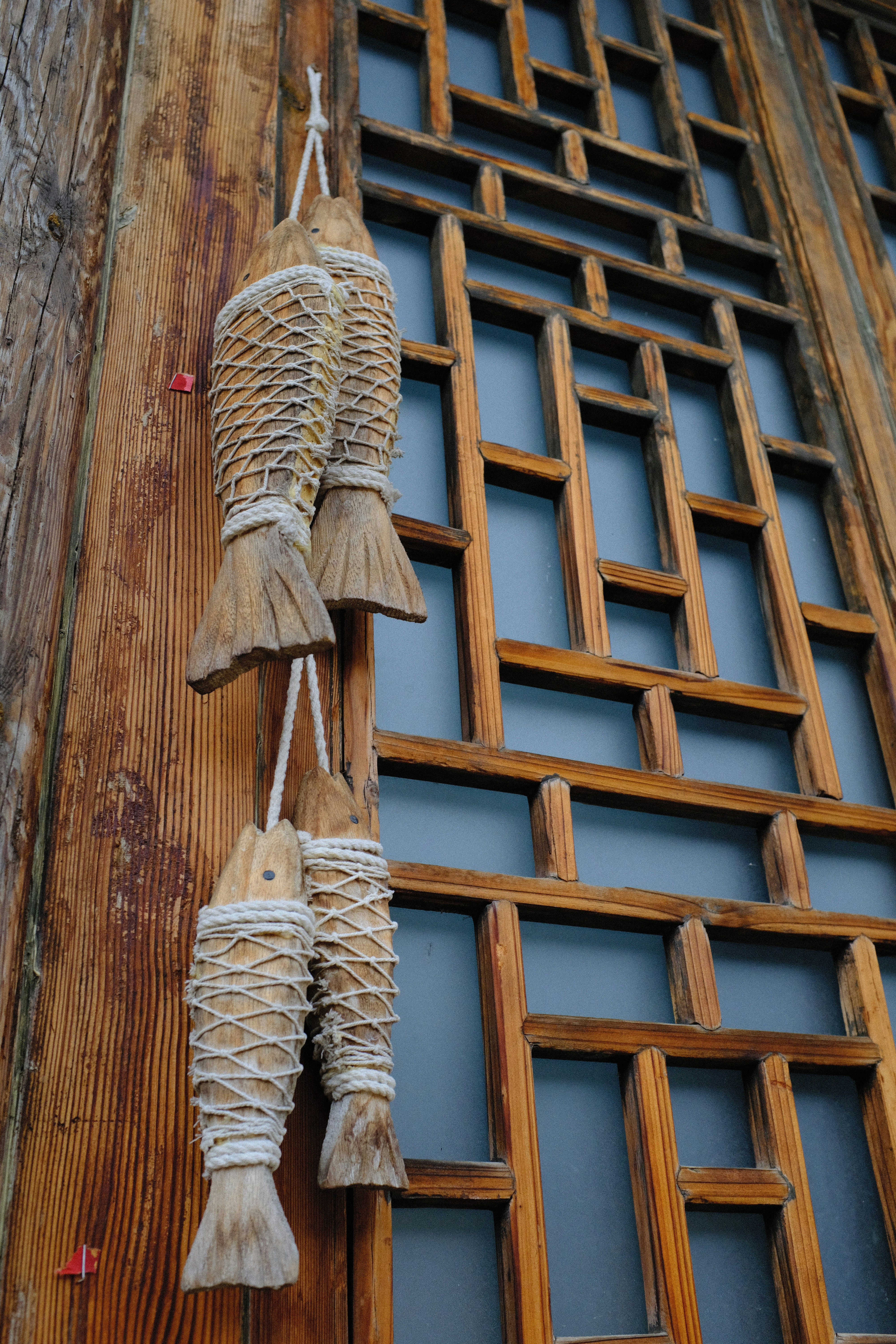 Wooden fish ornaments hang on a rustic door. photo – Free Interior ...