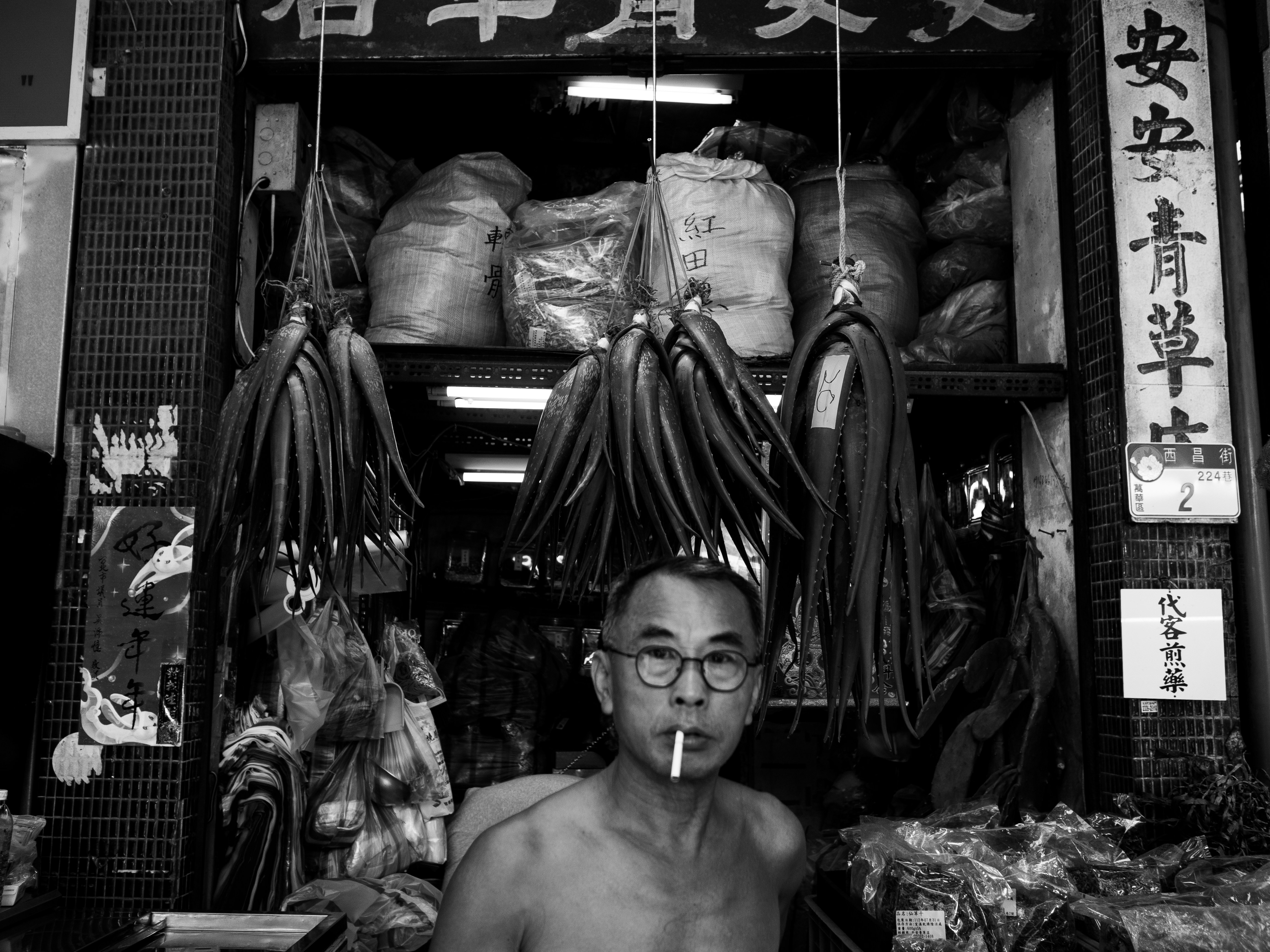 Cigarette and Gaze: Street Portrait Behind the Market Stall