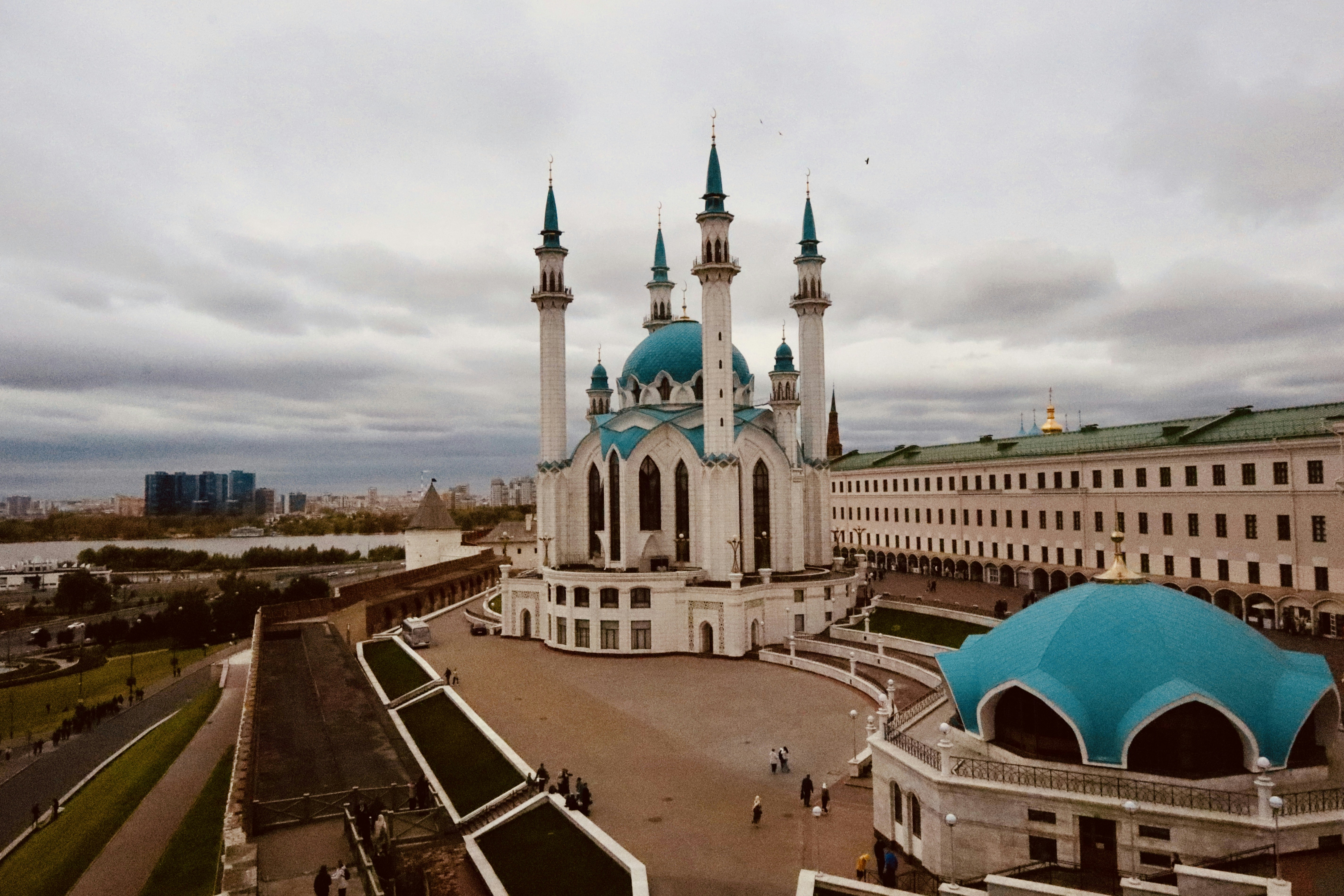 Blue-domed mosque rises over reflective courtyard and riverbank