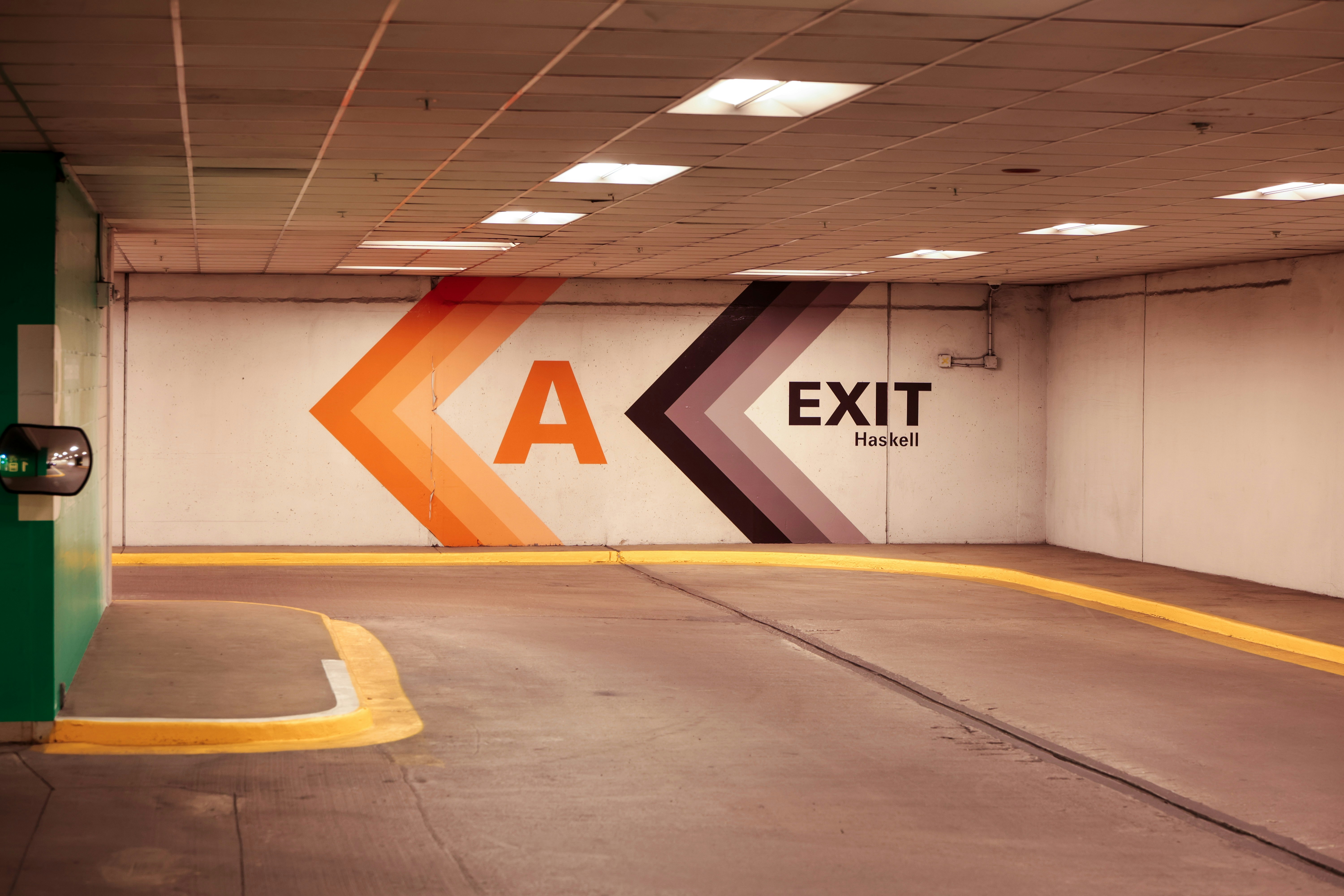 Arrowed Neon Gate: The A-Exit Within an Empty Parking Lot