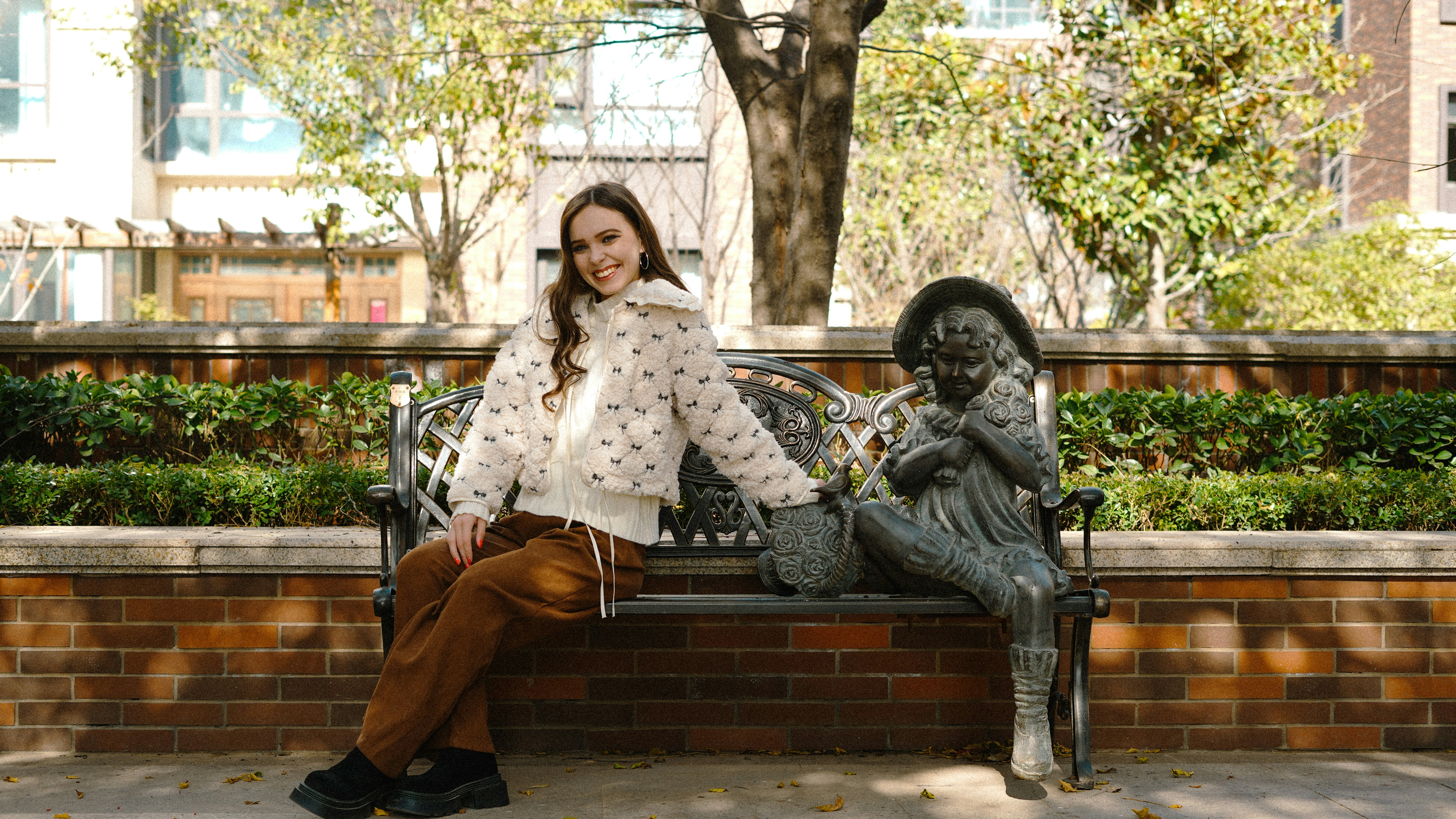 Cozy City Moment: Girl on a Park Bench with a Playful Statuesque Friend