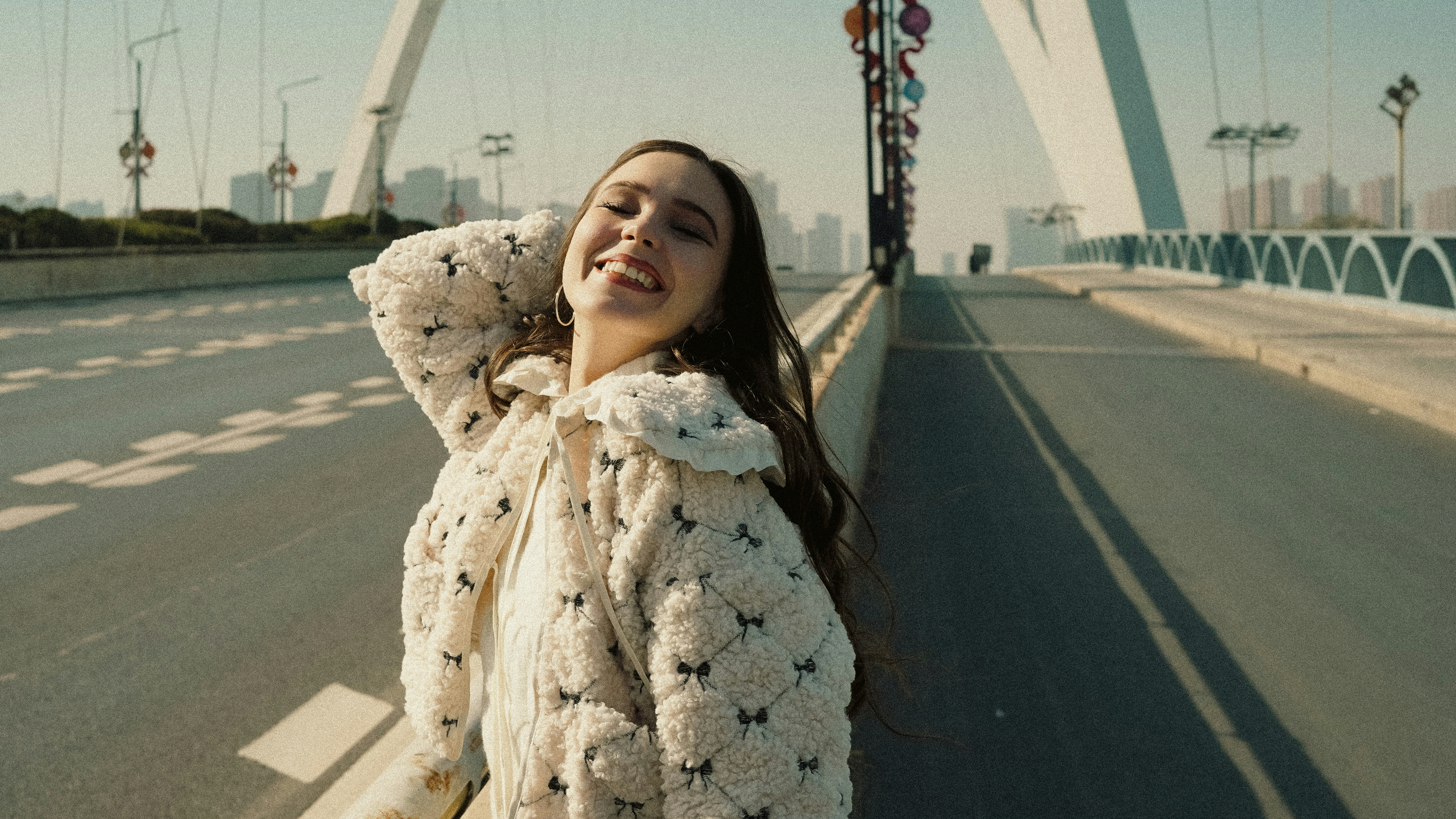  smiling on a sunlit bridge in plush fur coat 