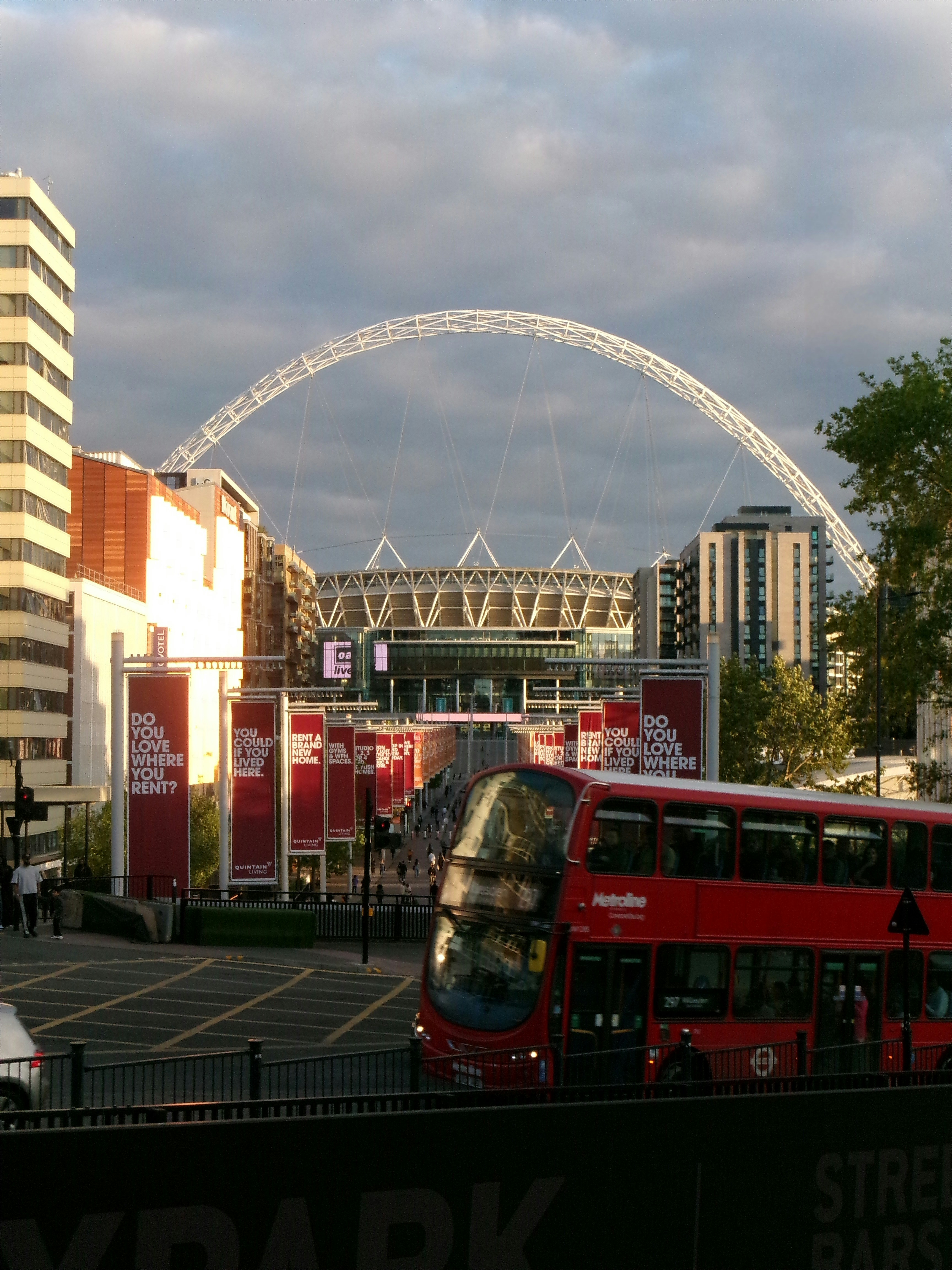 London’s Riverfront Confluence: Red Bus, Neon Banners, and the Arched Skyline