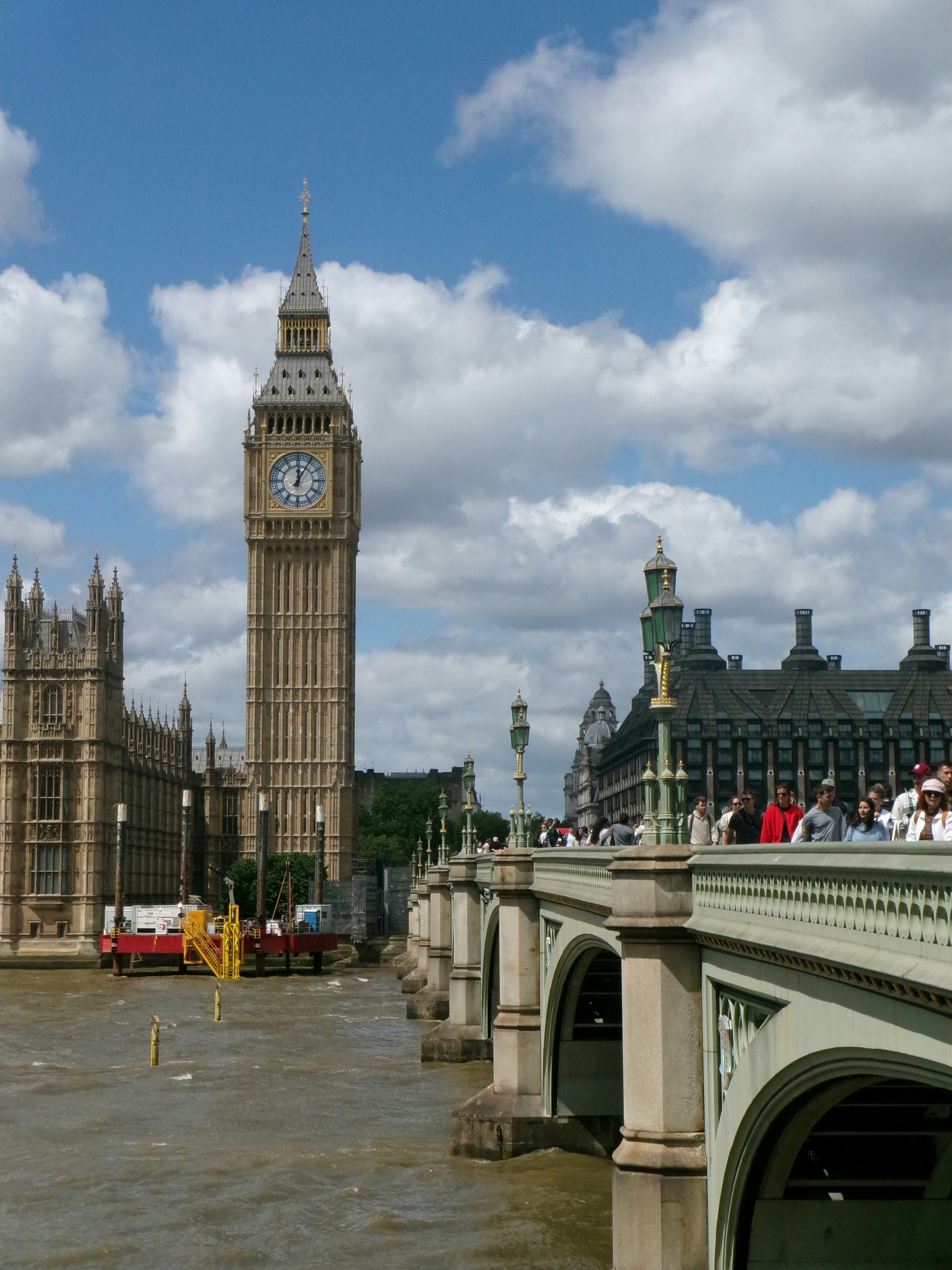 Big ben and westminster bridge under a cloudy sky.