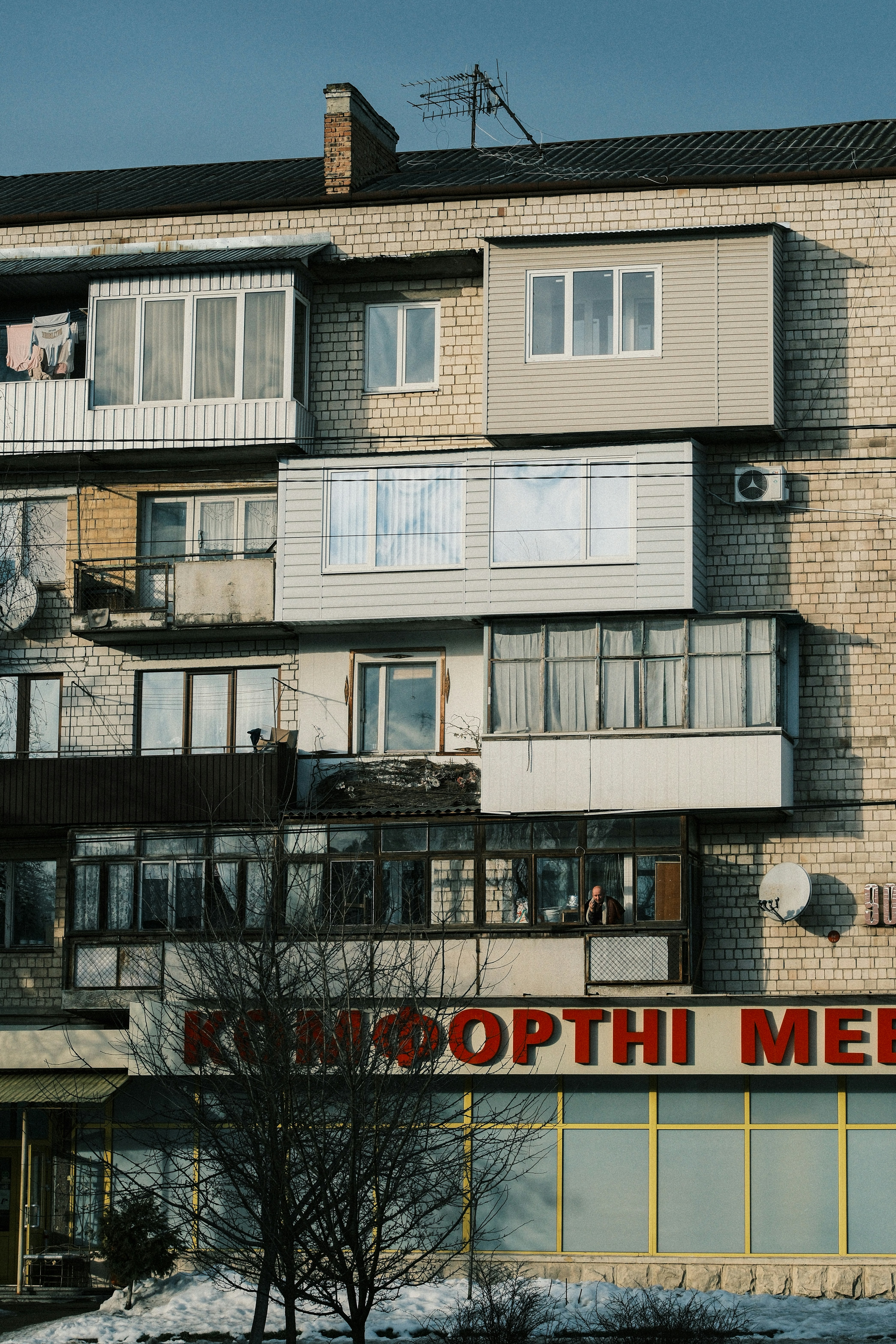 Apartment Block Facade: Rows of Enclosed Balconies and Cyrillic Signage