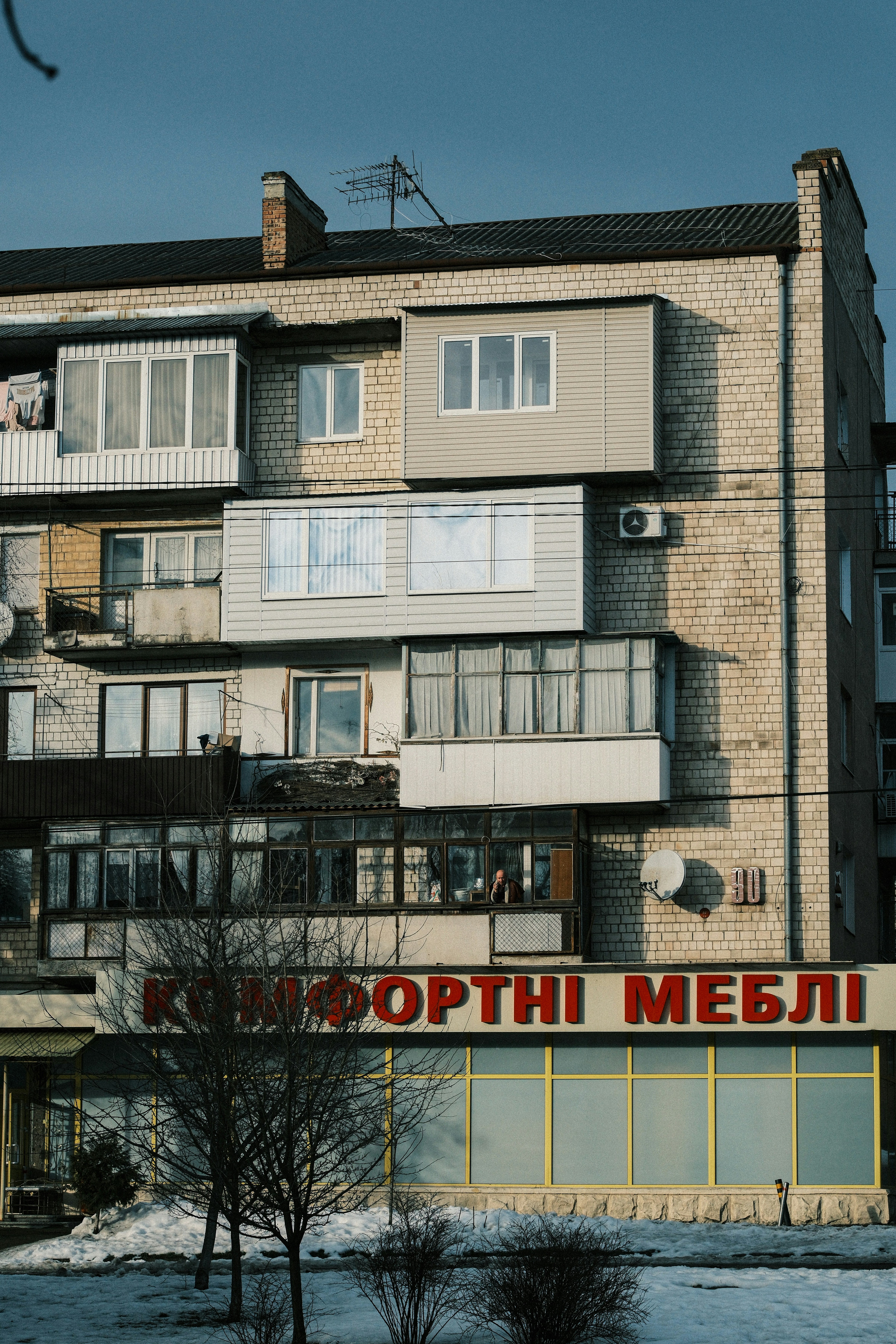 Ground-floor Red Sign, Windows, and Snow-Dusted Street
