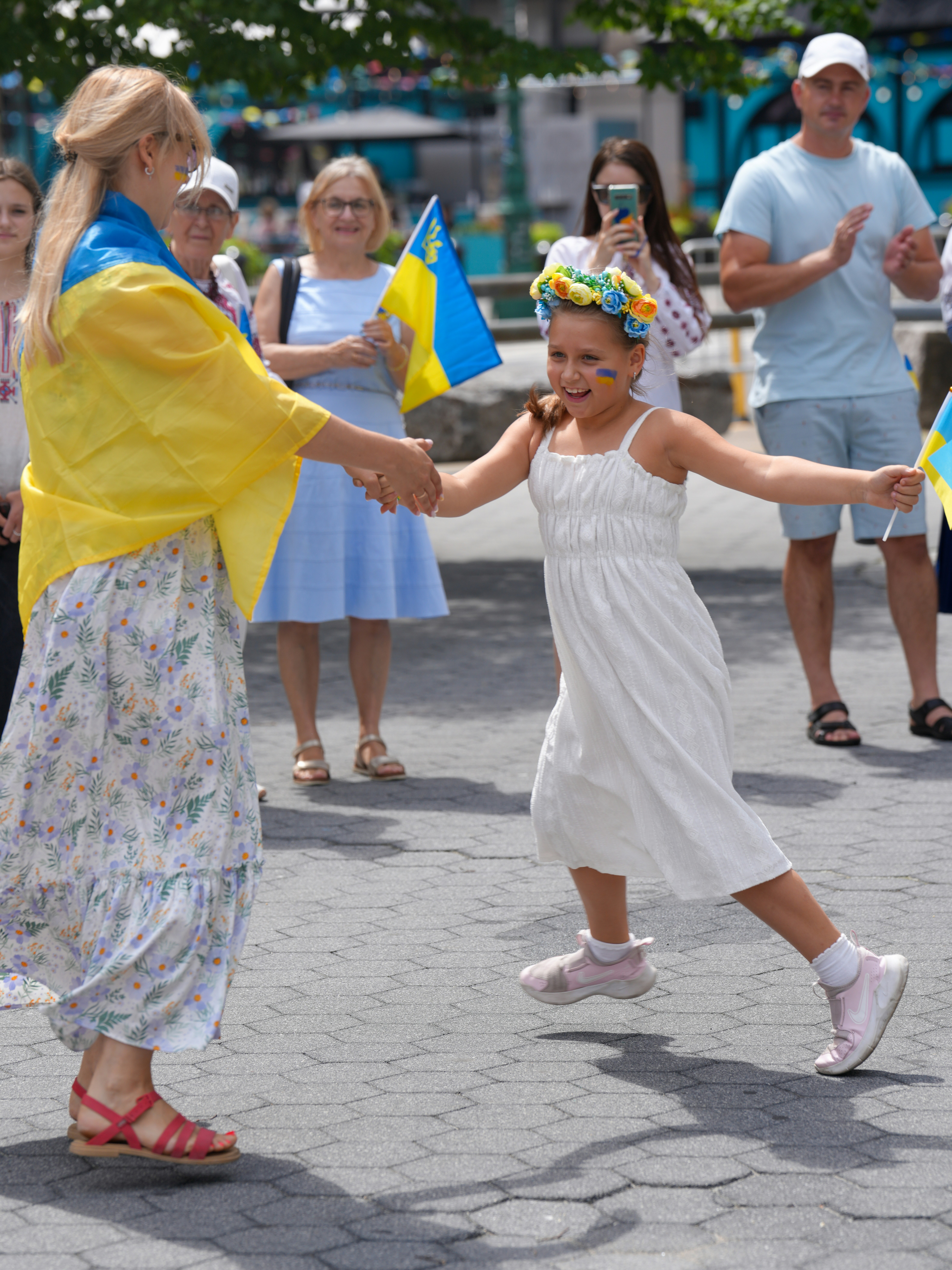 Joyful Ukrainian Celebration: A Young Dancer Reaches for a Hand in White Dress