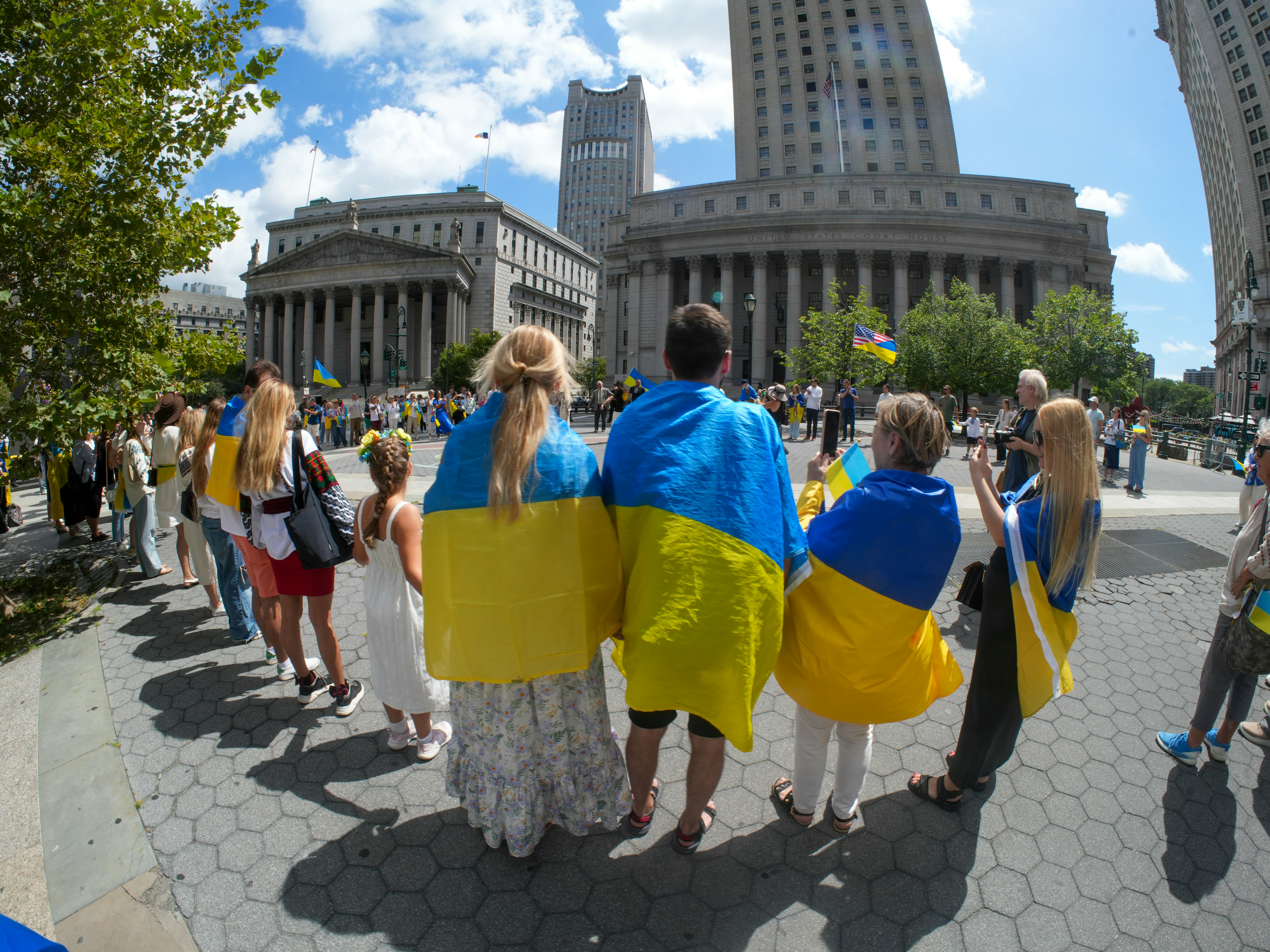 A peaceful New York City rally shows people standing in solidarity with Ukraine, holding blue-and-yellow flags and sharing moments of unity and resilience. Portraits and candid scenes capture emotion, determination, and community spirit. Photographed by Alex Buzunov @buzunov.photoart, this documentary-style image reflects hope, cultural pride, and the power of peaceful voices.