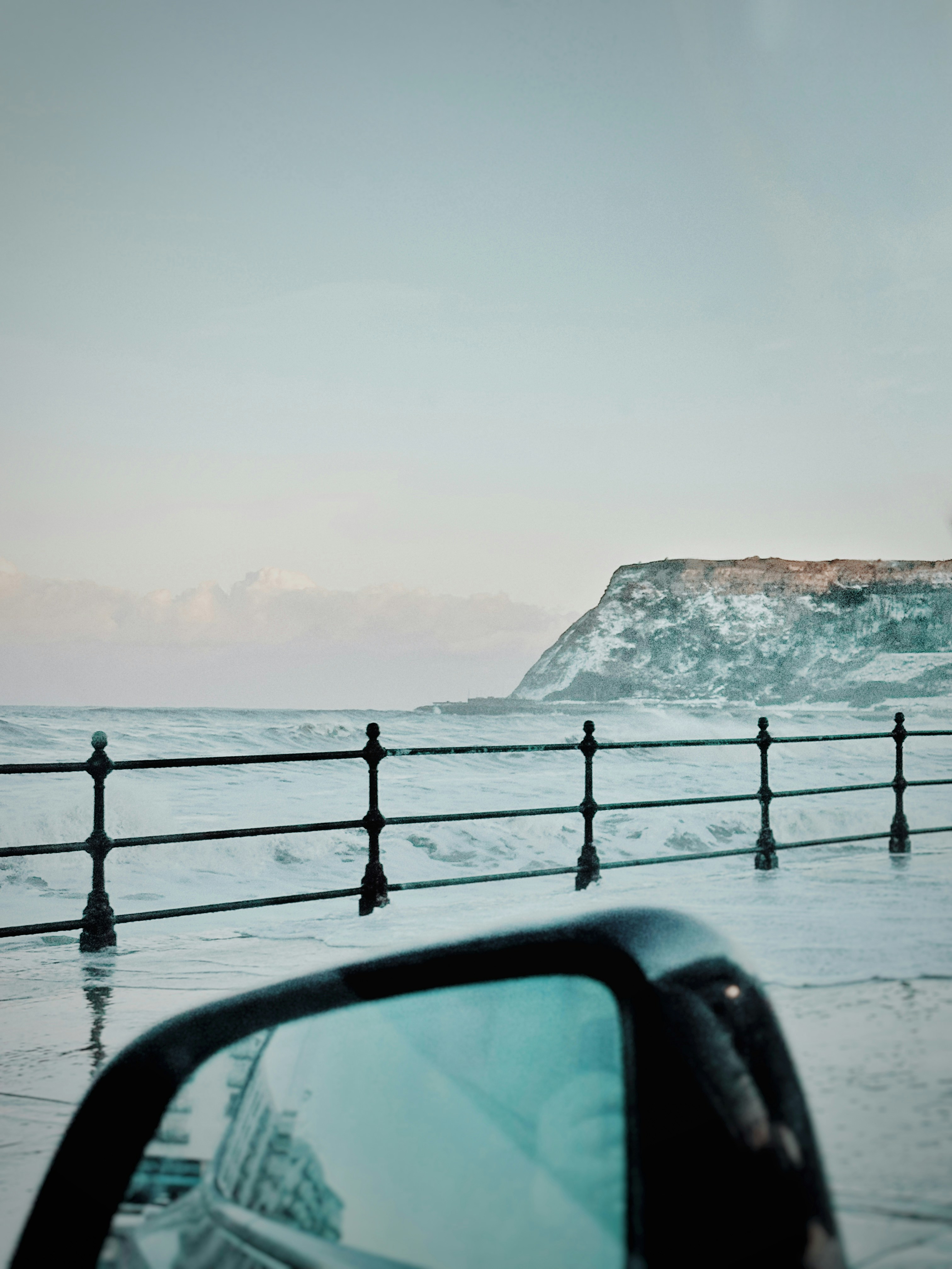 Coastal View Reflected: A Car Window Framed by Sea Railings