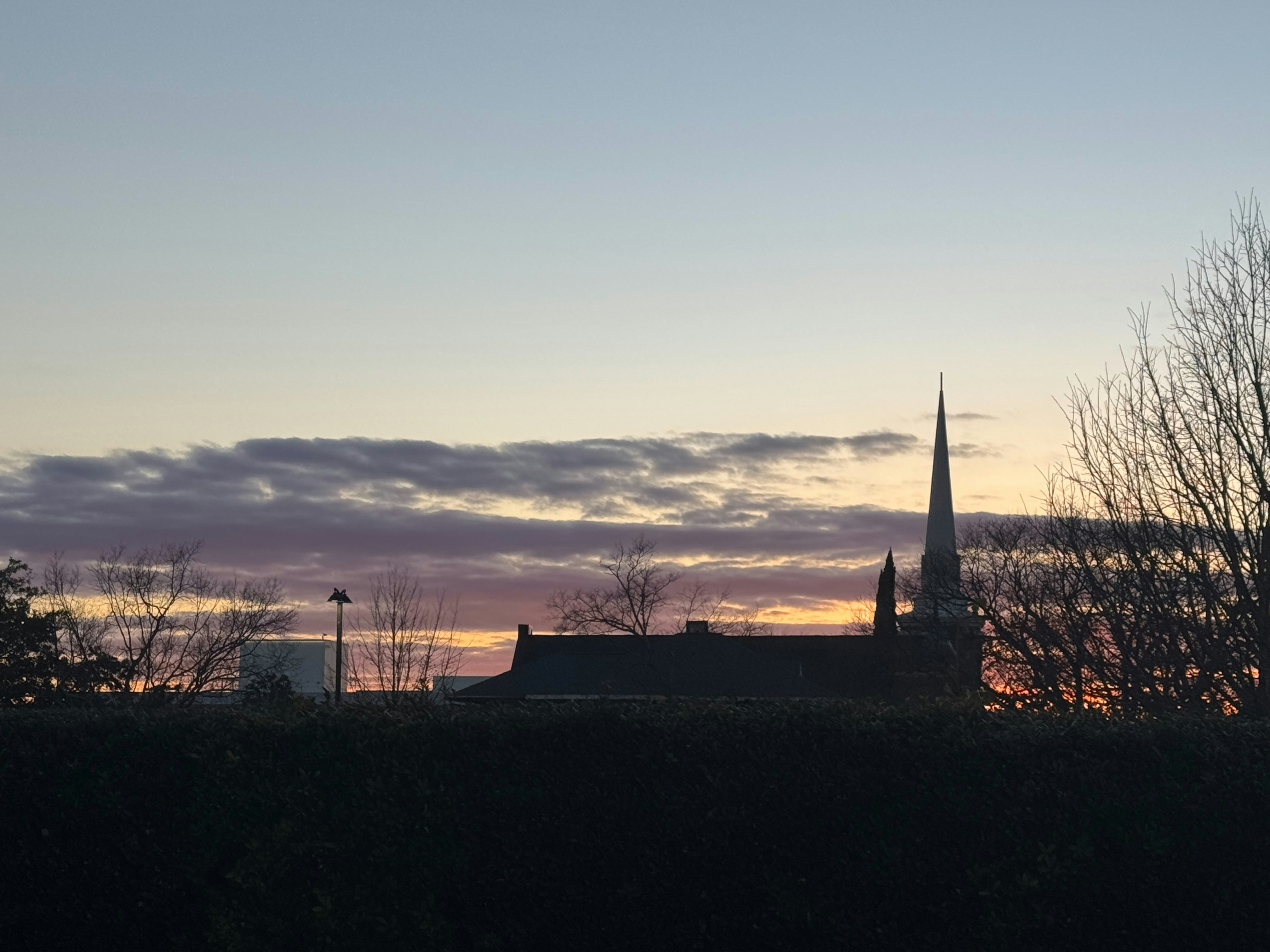 Silhouette of a church and trees at sunset
