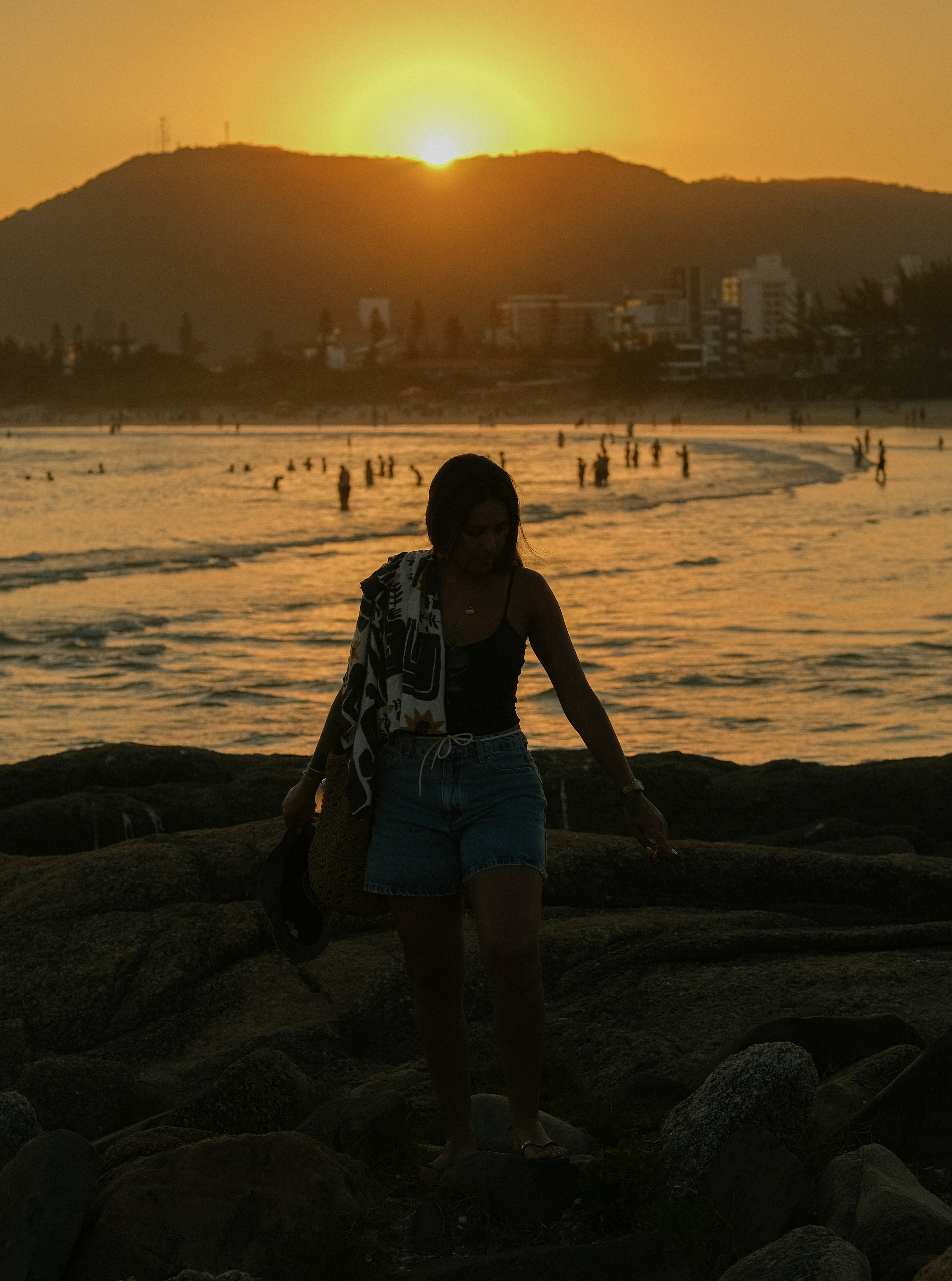 Sunset Silhouette: A Coastal Stroll past the Dusk-Hued Wave Breakers