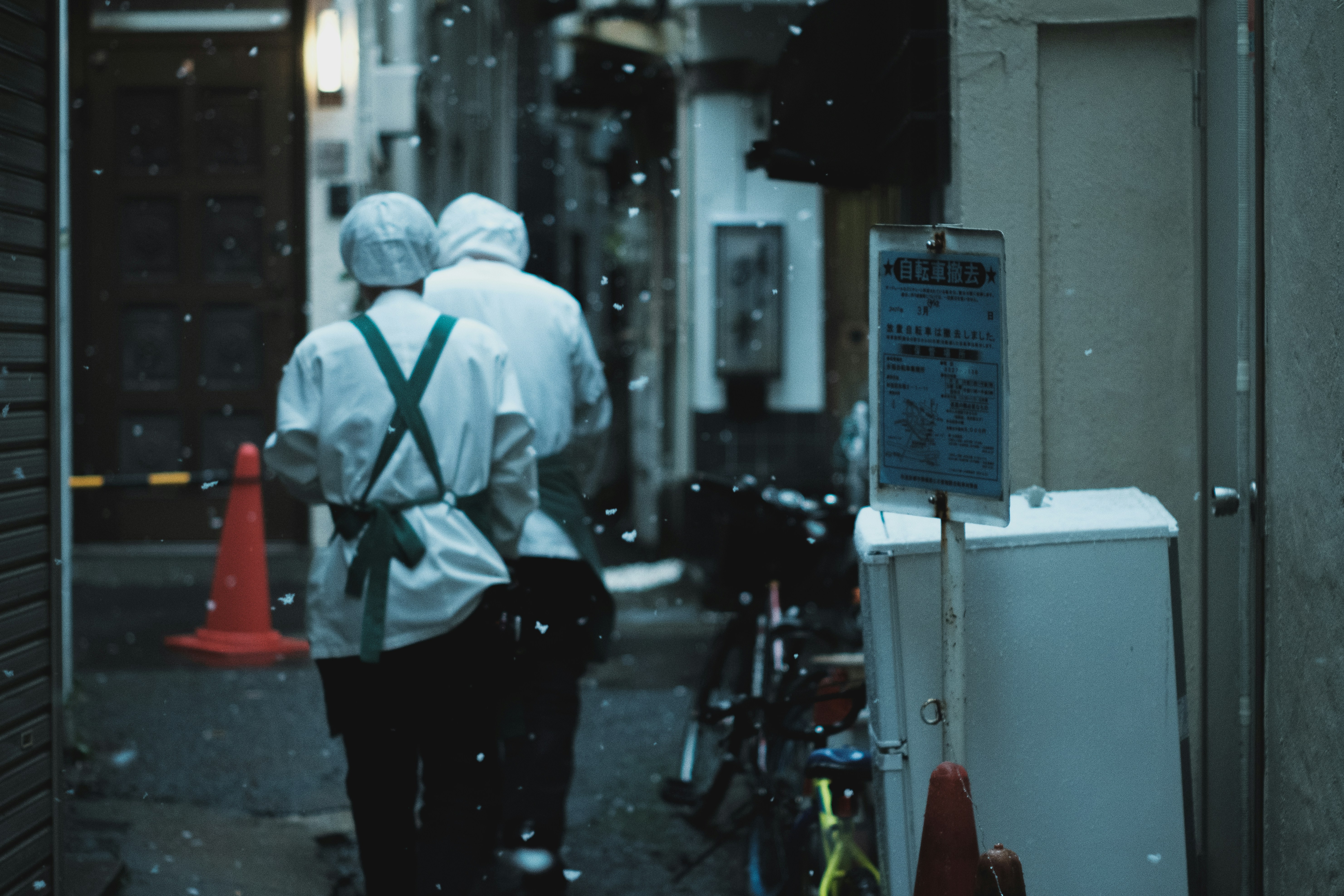 Covid-district corridor: healthcare workers in white gowns march through rainy alley