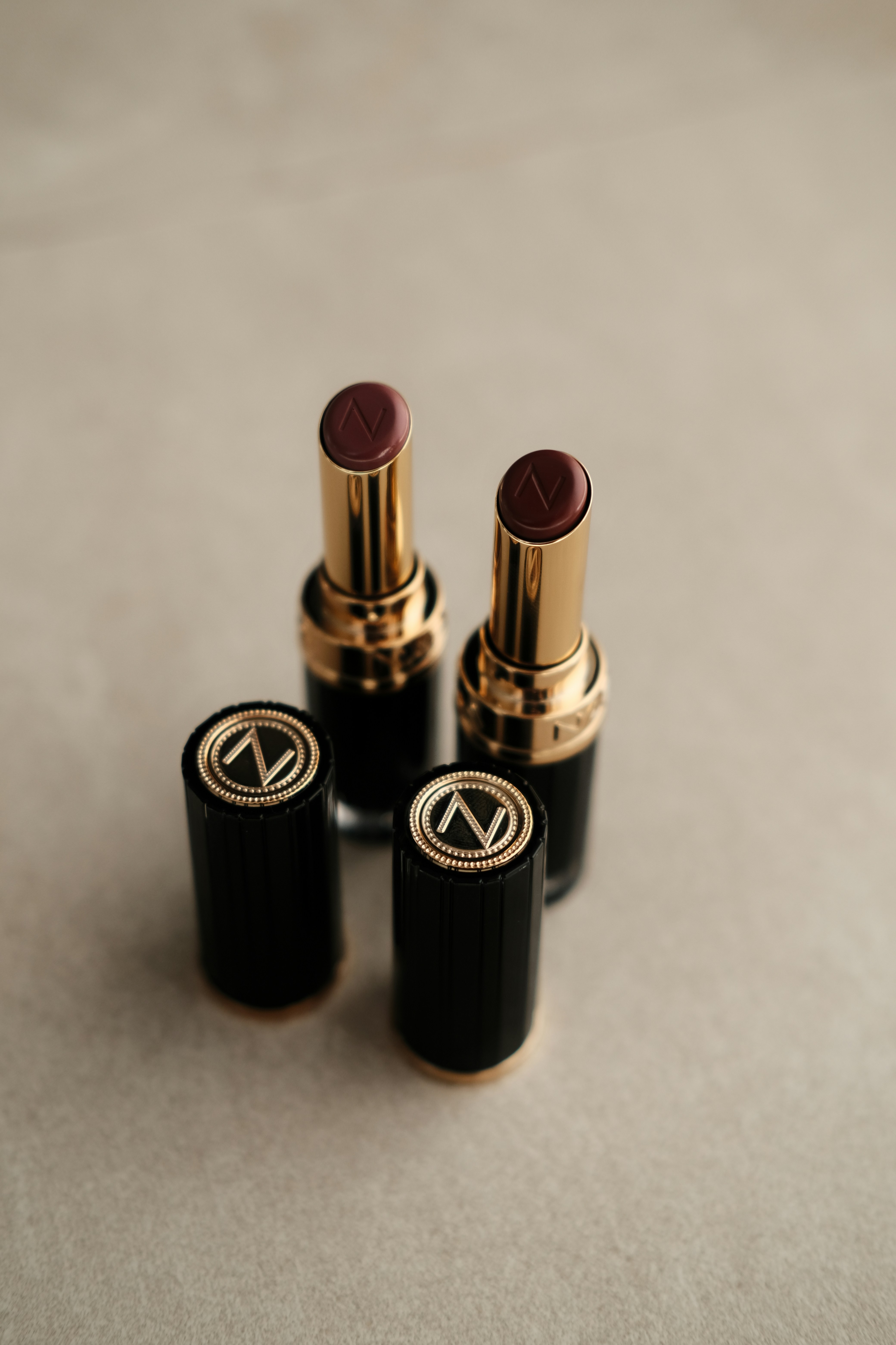 Gilded Stacks: Lipsticks Stand Tall in Soft Focus