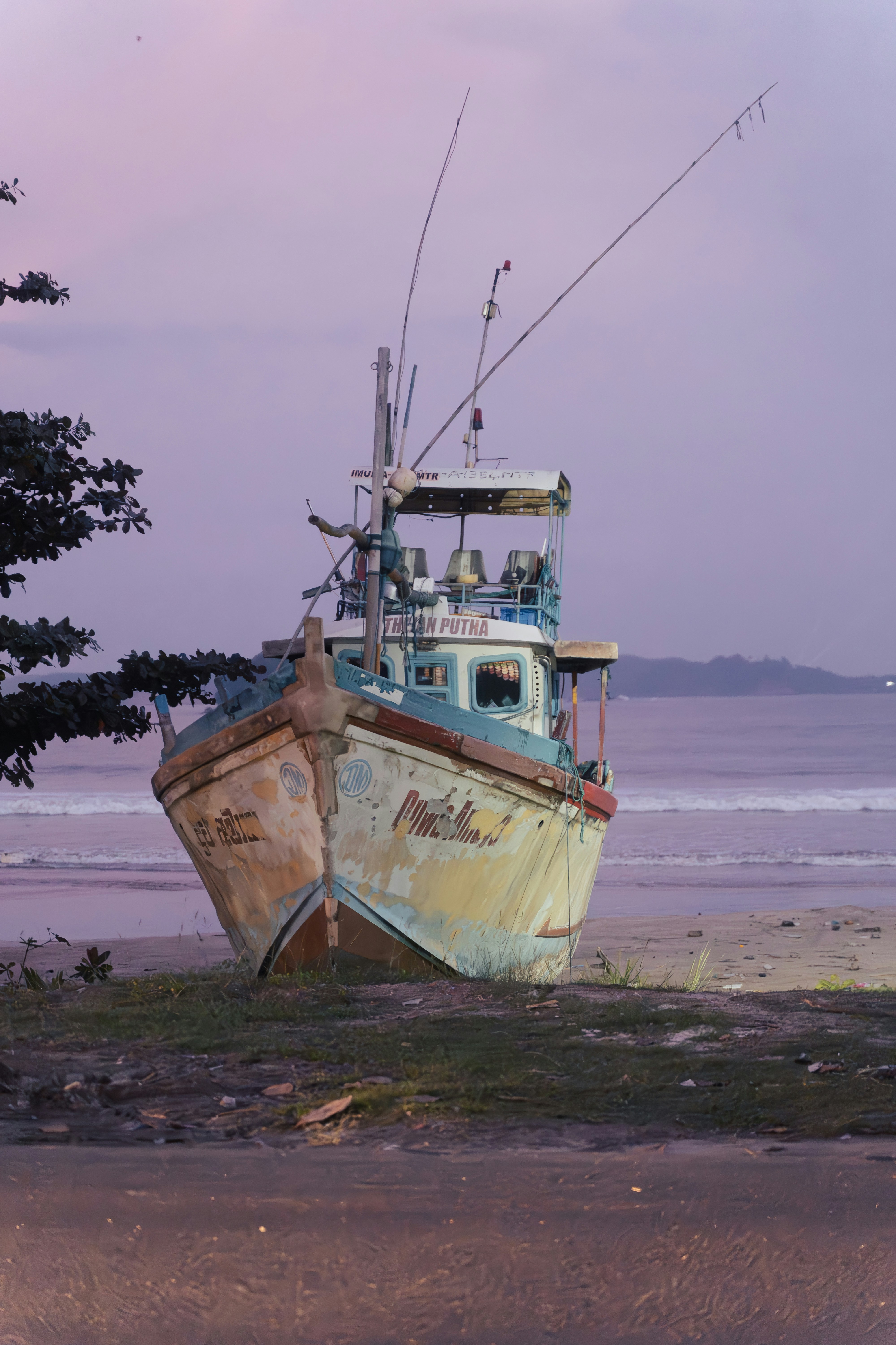 Weathered fishing sloop at low tide, bathed in pastel twilight