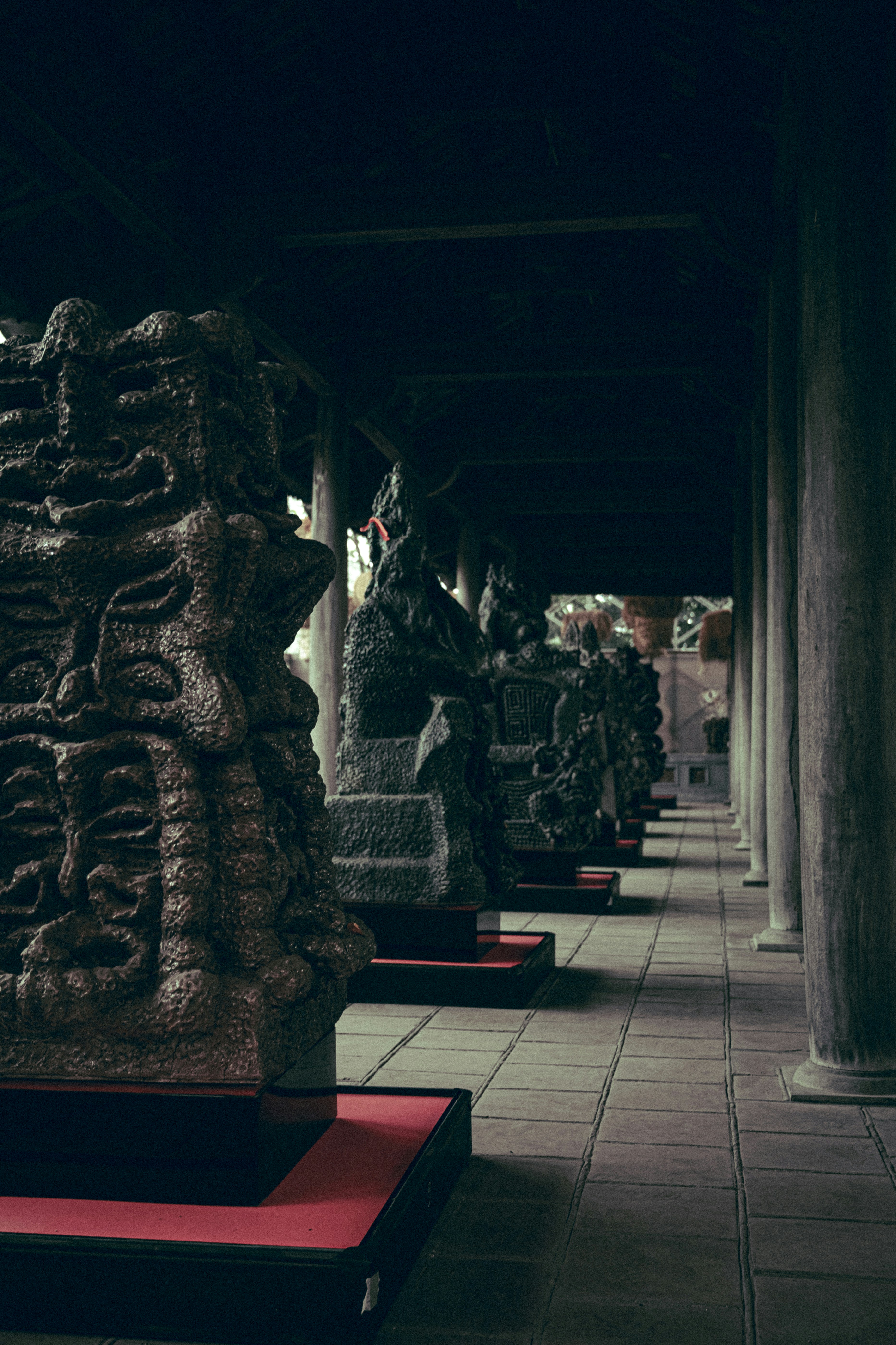 Row of Guardian Statues Lining a Dim Corridor