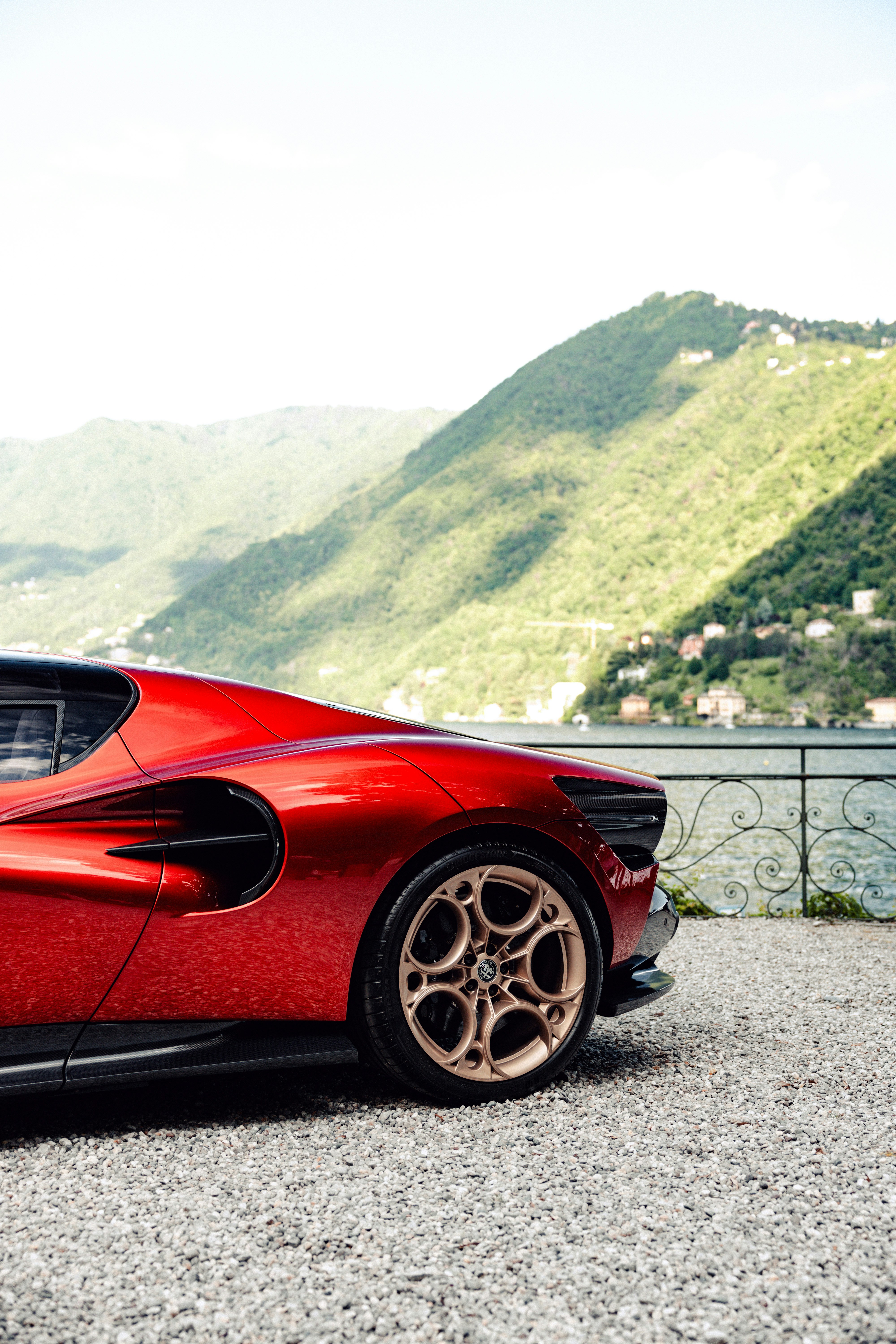 Red prowler by the lake: a luxury hypercar meets Alpine horizon