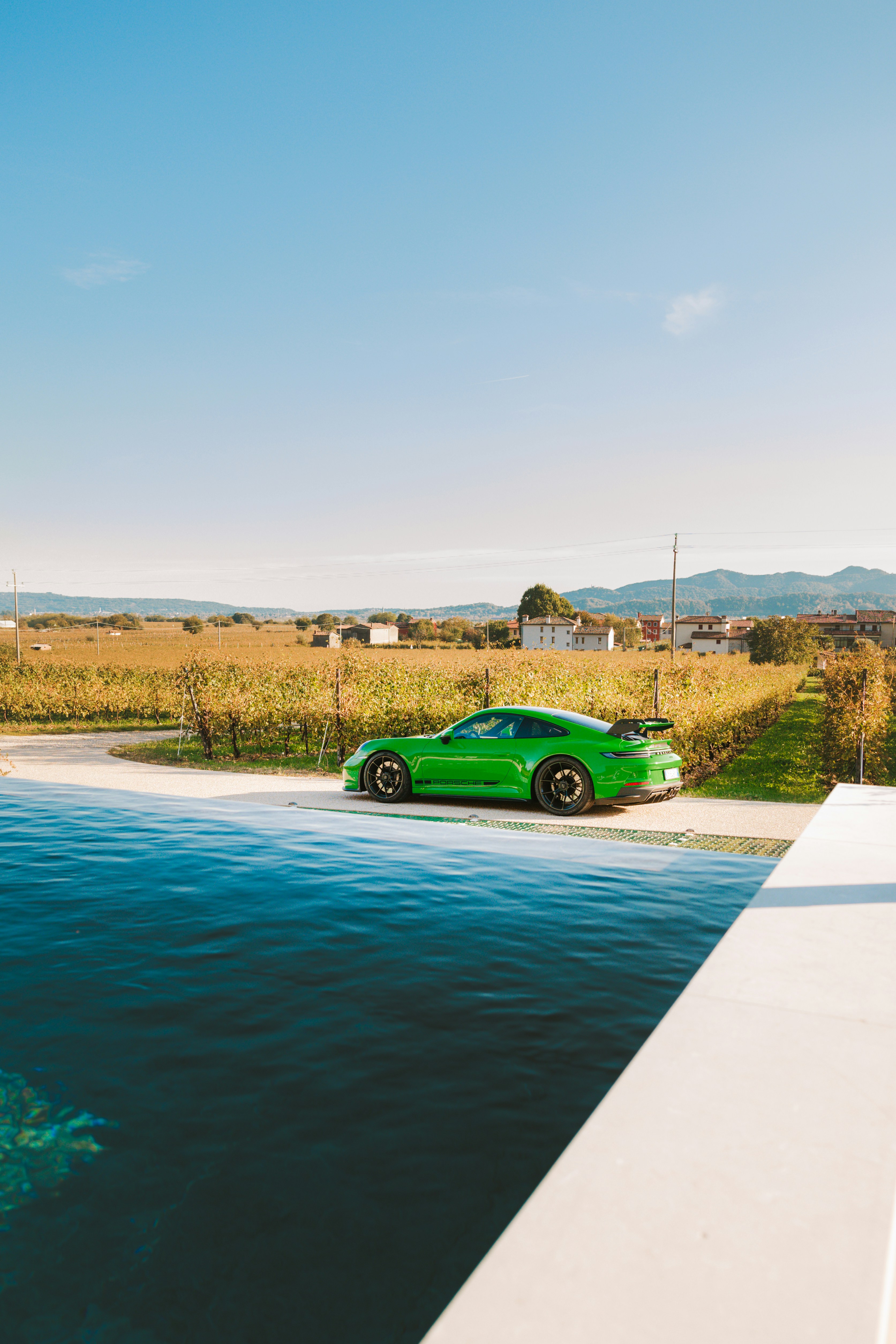 Green sports car parked beside an infinity pool photo – Free Porsche ...
