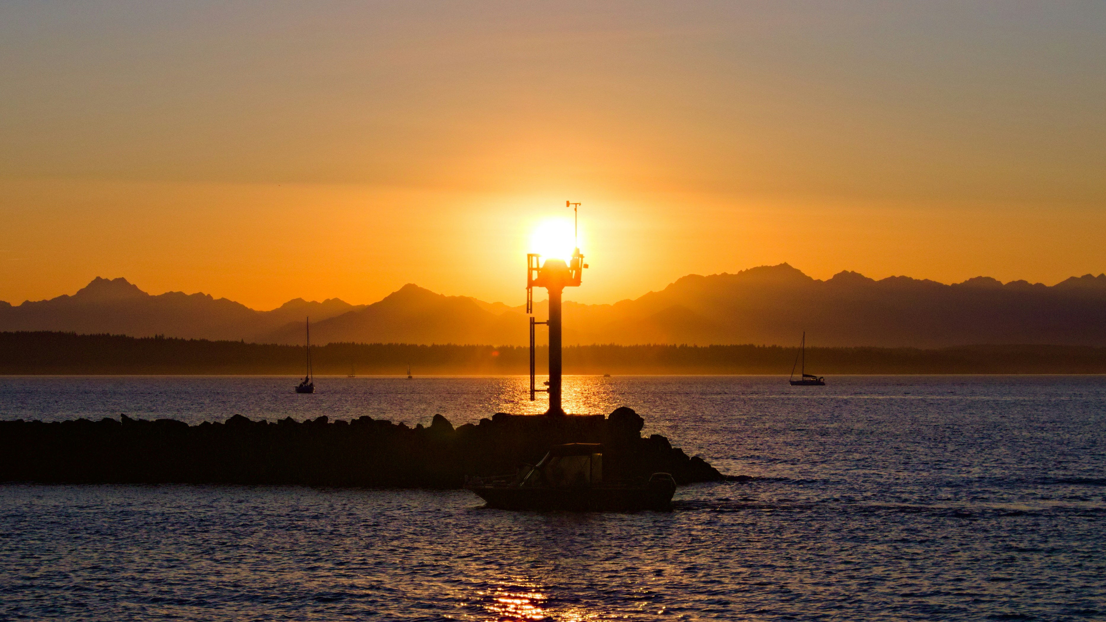 Sunlit beacon at dusk: silhouette against a calm horizon