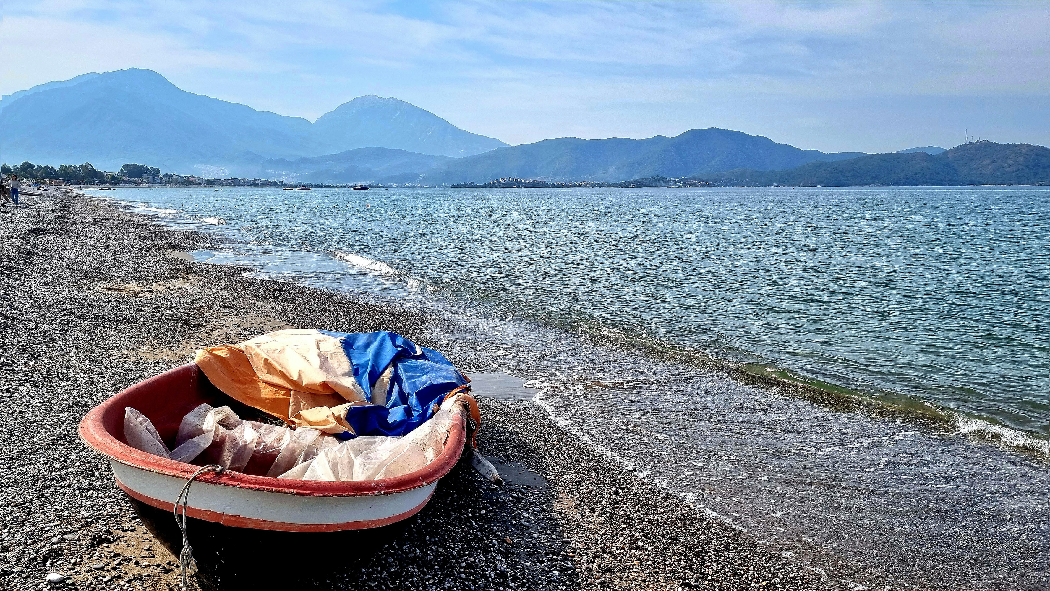 A Small Boat on a Quiet Lake with Distant Blue Mountains