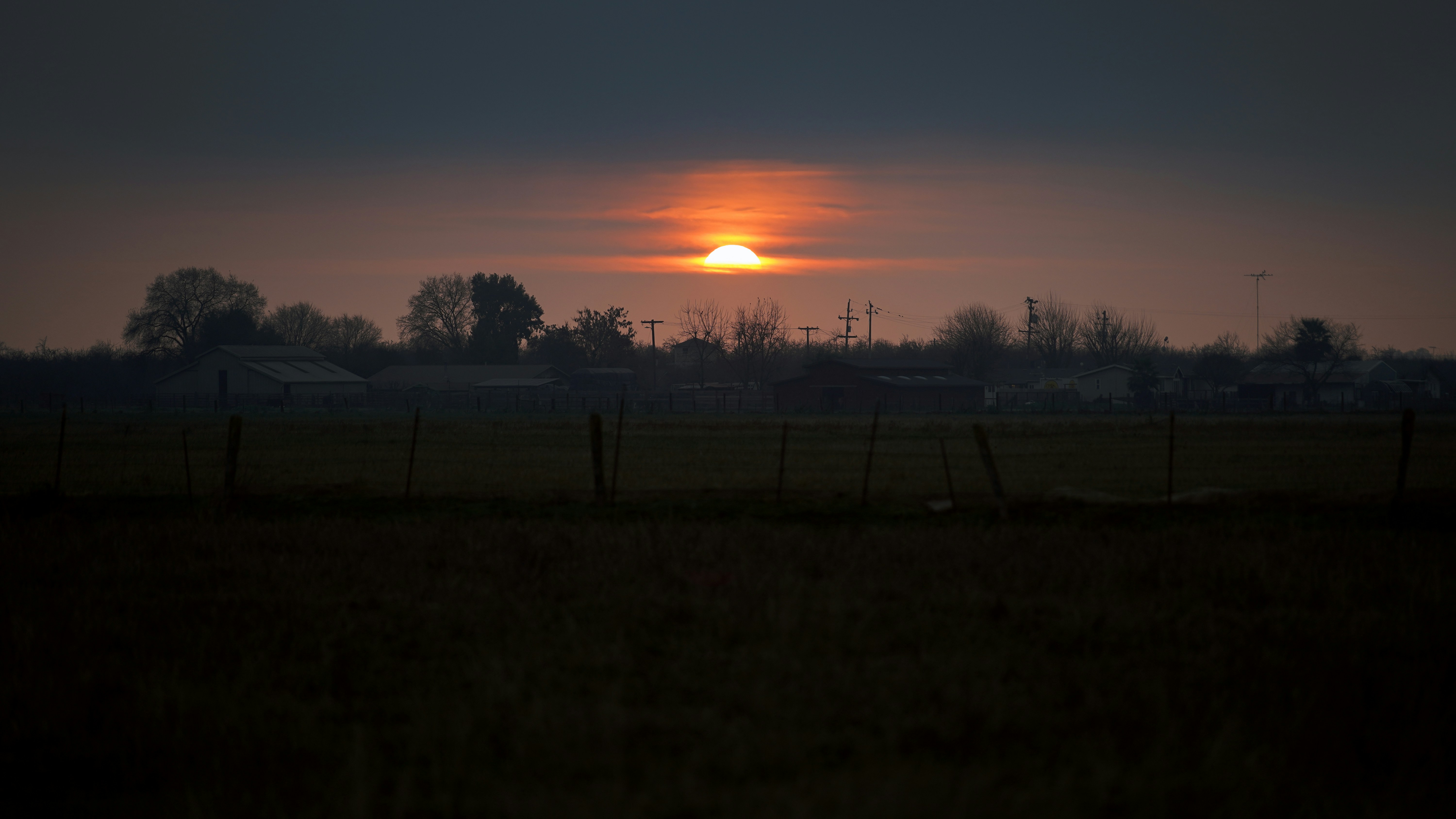 Sunset Over Quiet Fields: A Distant Horizon With Soft Warmth