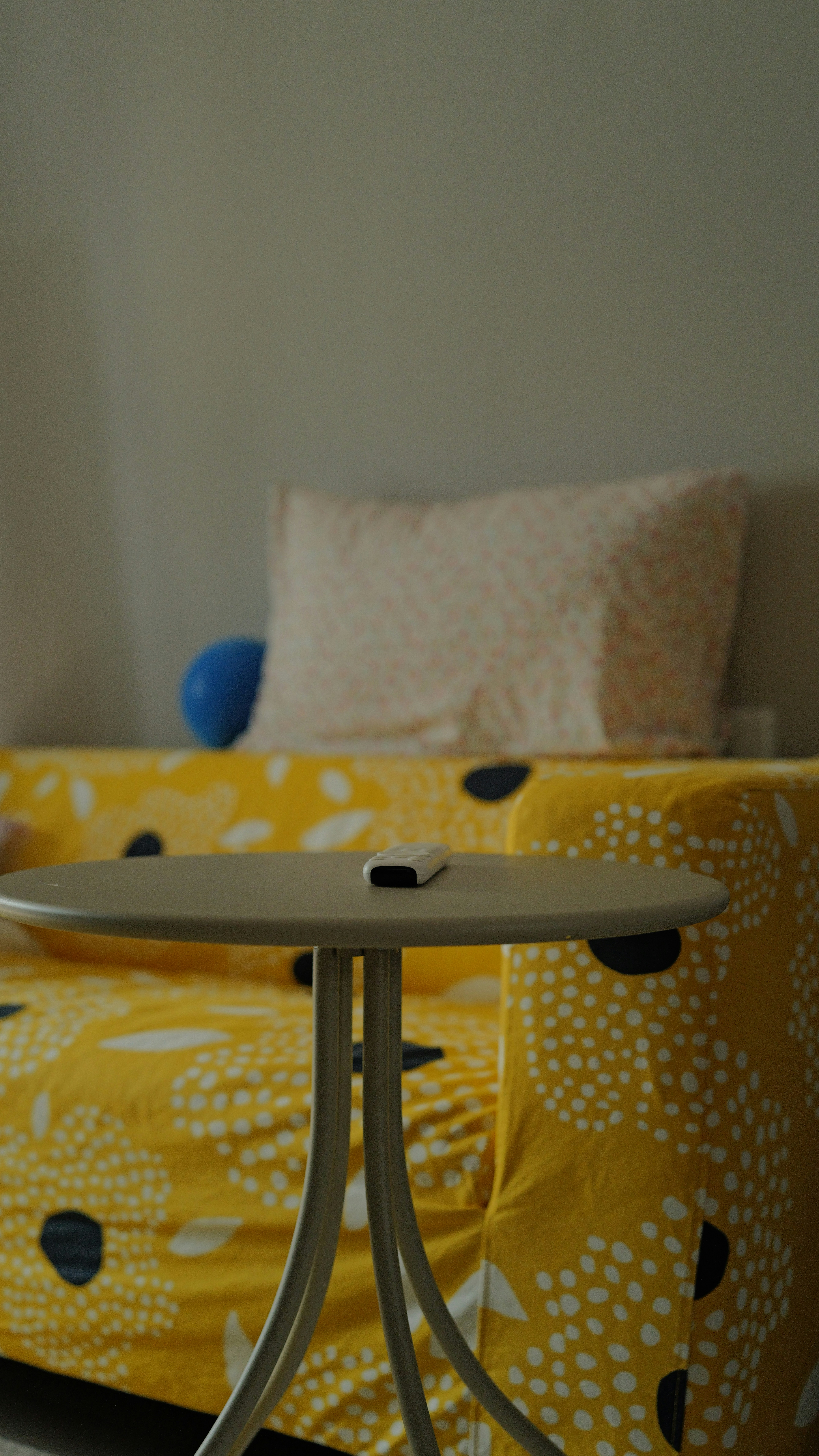 Sunny Living Room Corner with Yellow Floral Sofa and Minimal Table