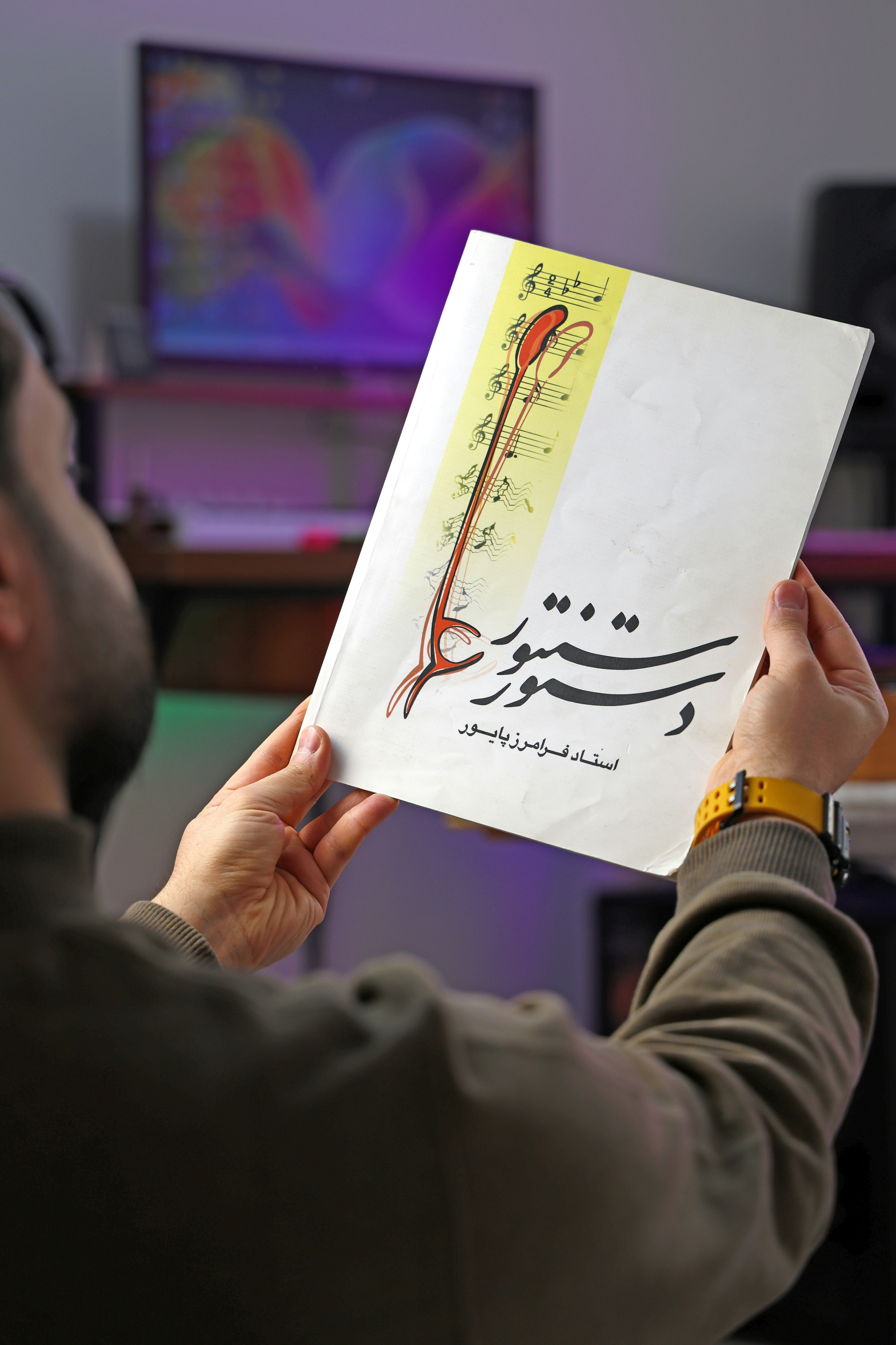 Holding a Musical Manuscript Under a Colorful Screen Glow